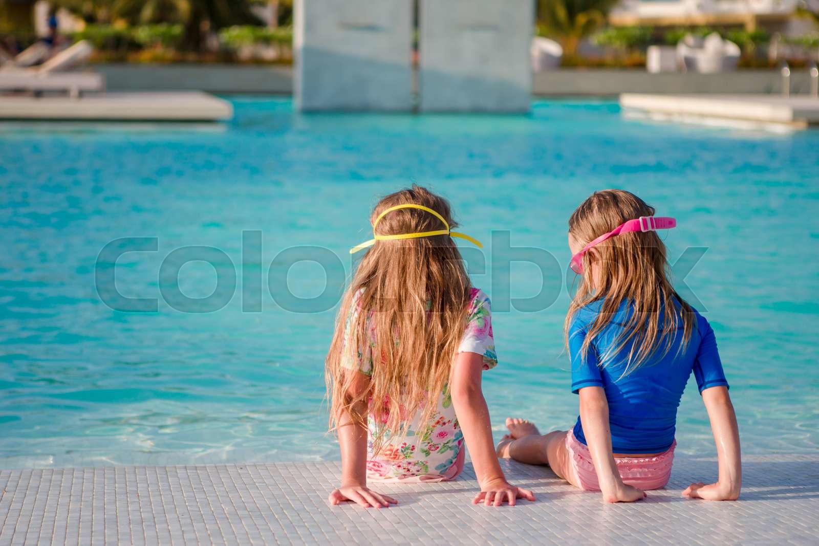 Adorable little girls playing in outdoor swimming pool | Stock image ...