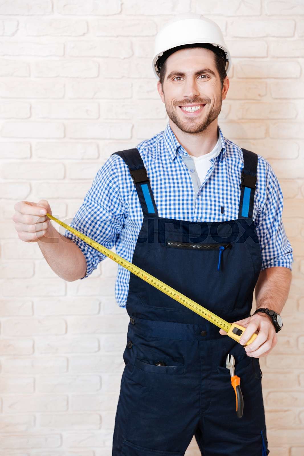 Handyman working using yellow tape indoors | Stock image | Colourbox