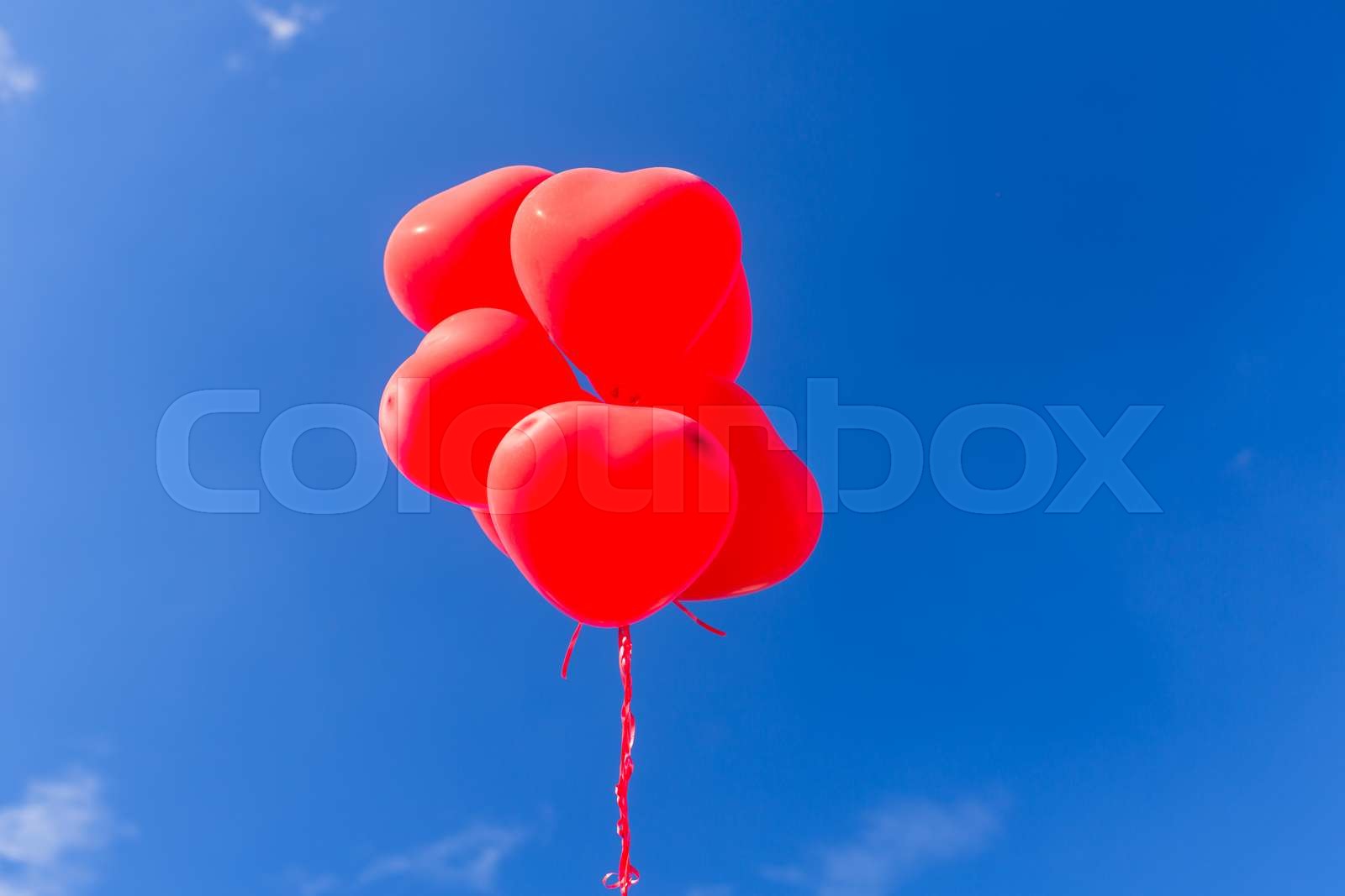 Red heart shaped helium balloons flying in the sky | Stock image ...