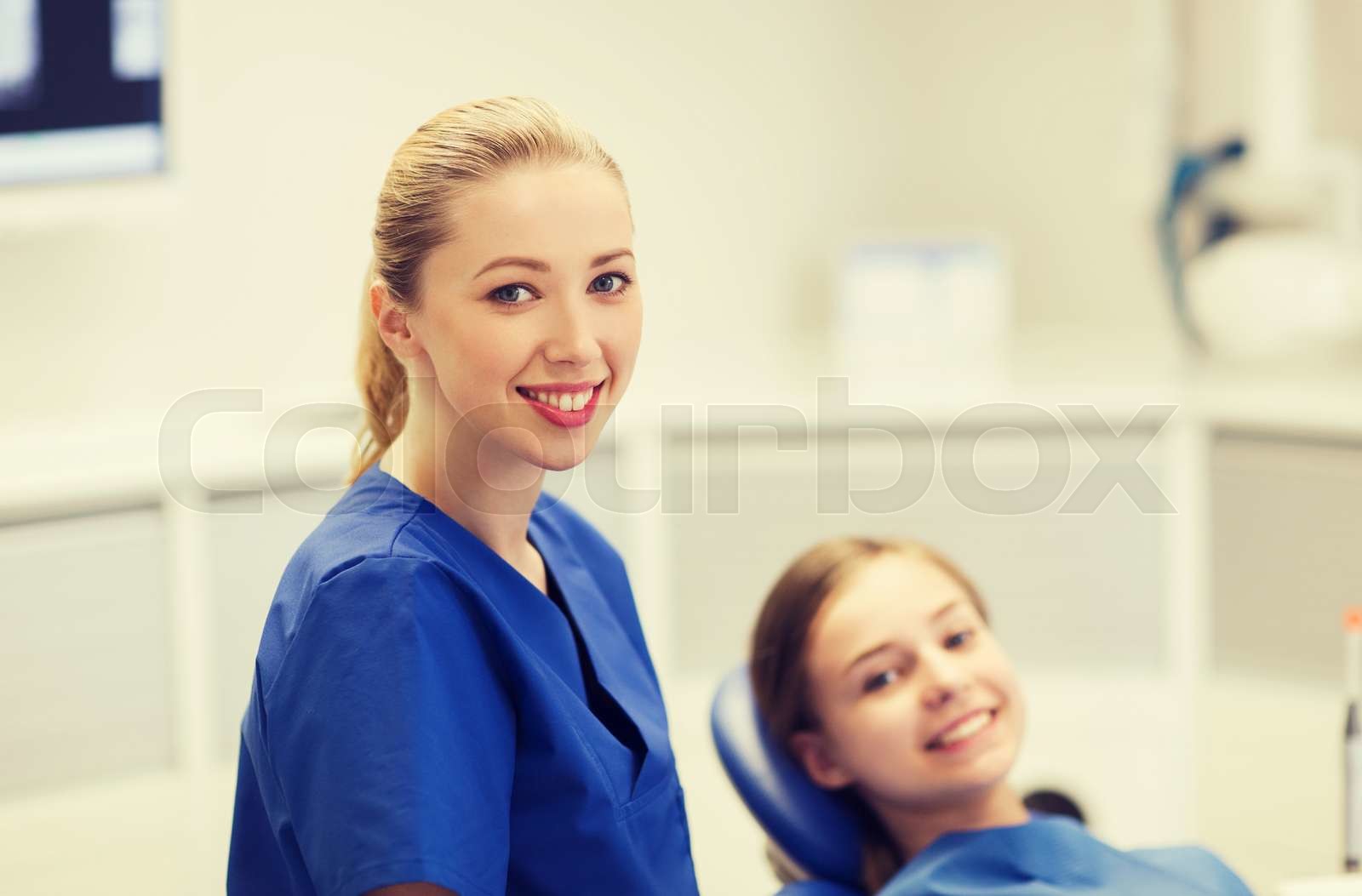 happy female dentist with patient girl at clinic | Stock image | Colourbox