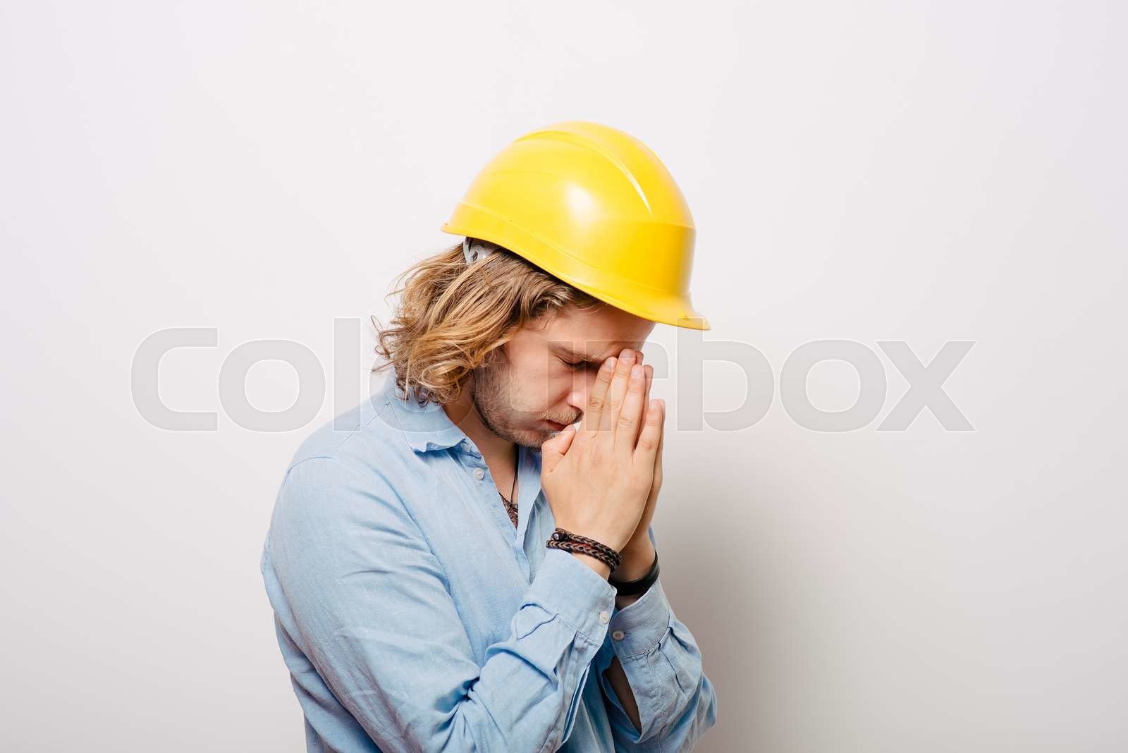 Construction worker praying | Stock image | Colourbox