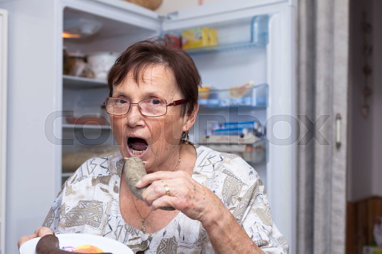 Senior woman eating pork liver sausage | Stock image | Colourbox