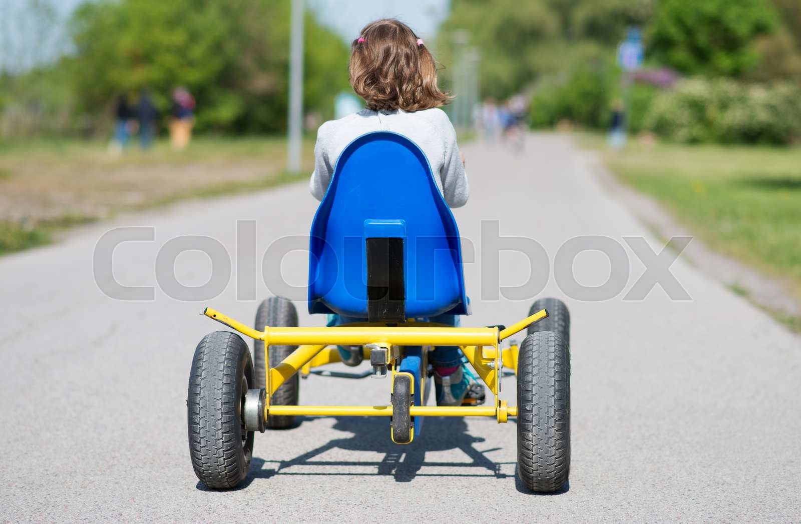 Little girl riding on pedal karting. | Stock image | Colourbox