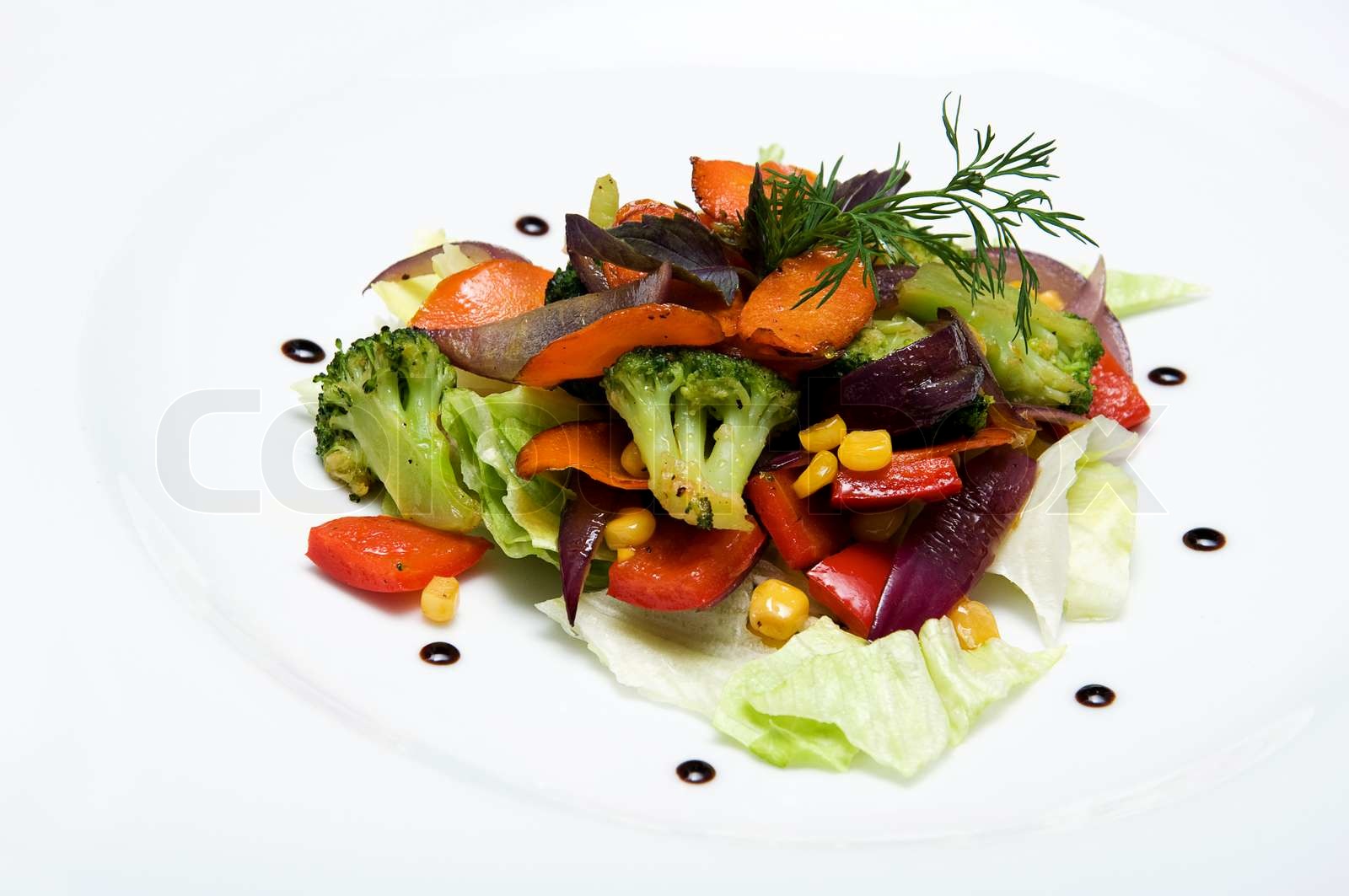 Grøntsager salat med majs, salat, sød peber og broccoli på hvid plade ...