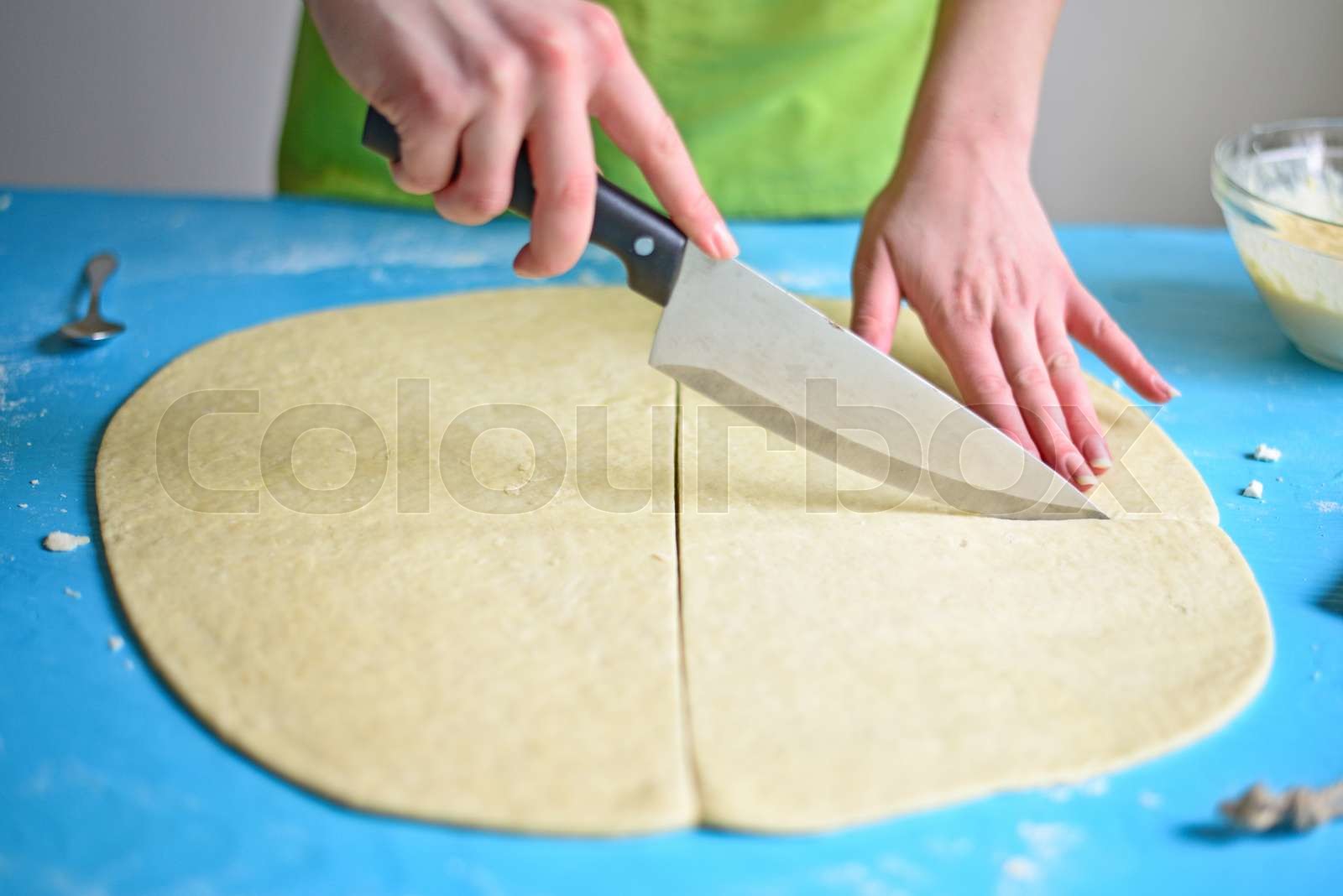 Cutting raw dough in flour with a knife | Stock image | Colourbox