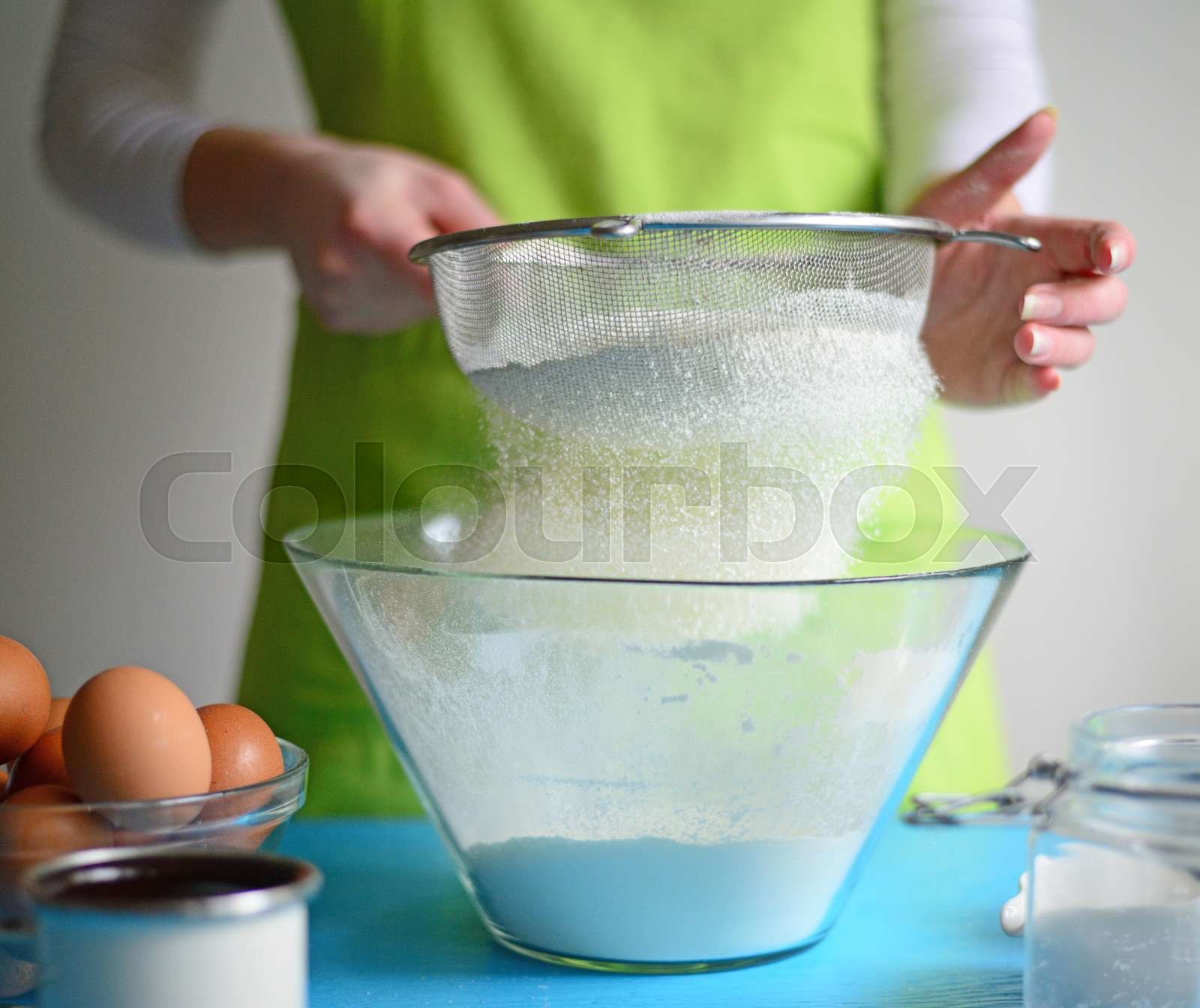 Flour sifting through a sieve for a baking | Stock image | Colourbox