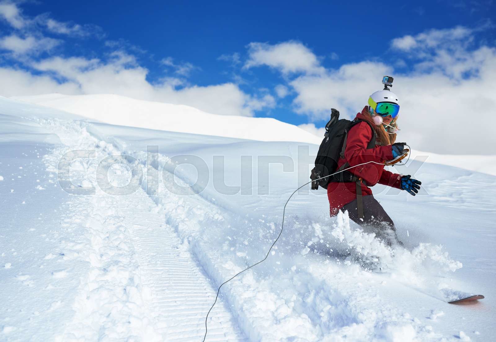 girl snowboarder rides a snowboard towed holding rope. | Stock image ...