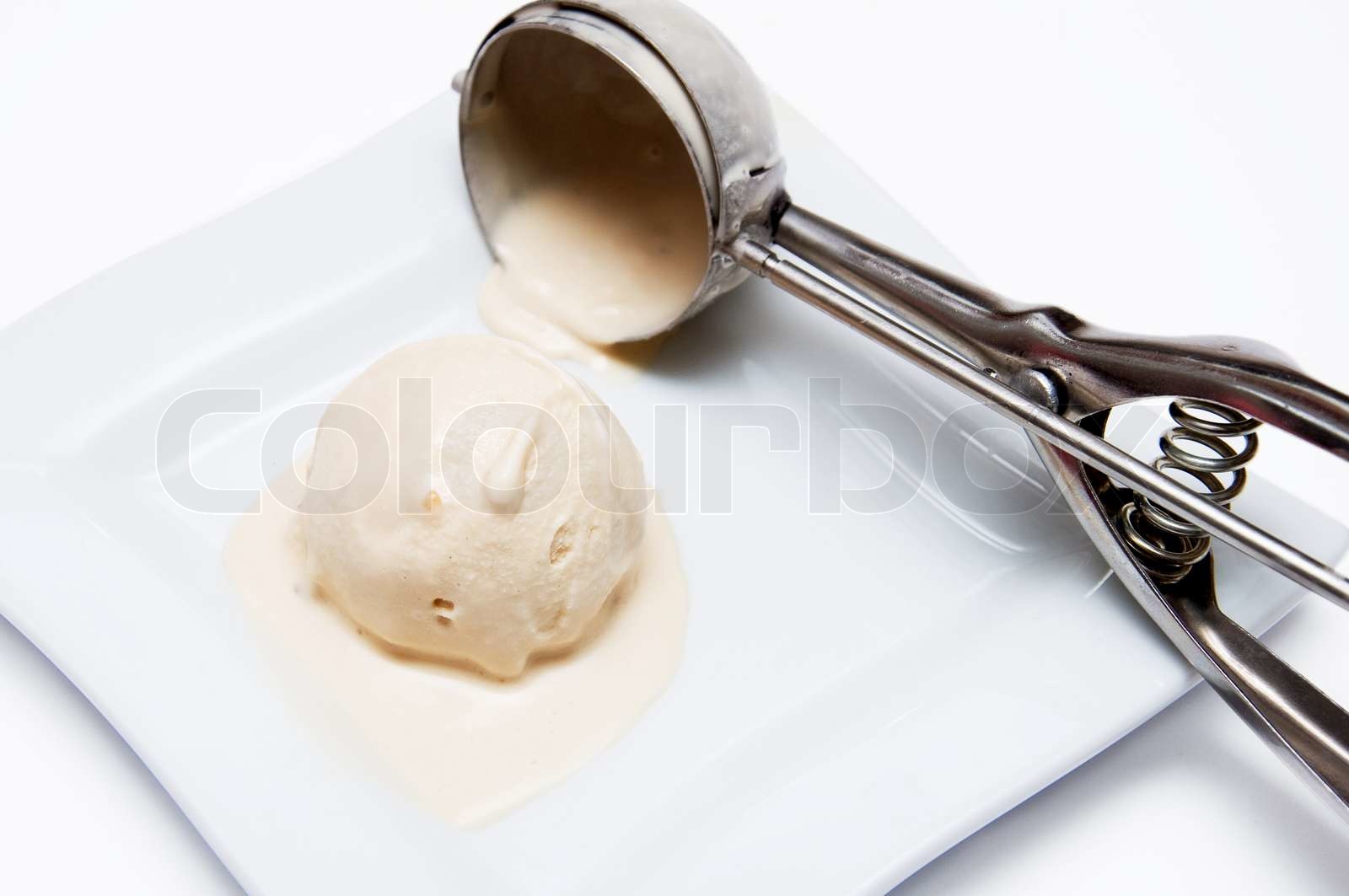 melting ice cream on a plate with a ice cream scoop | Stock image ...