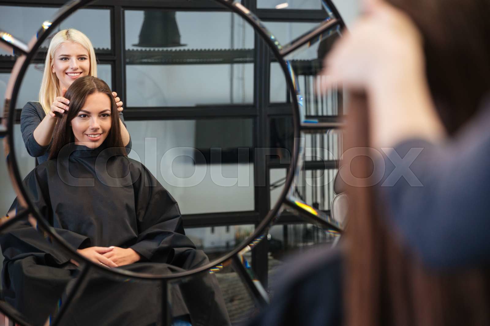 Mirror reflection of woman getting her haircut by stylist | Stock image ...