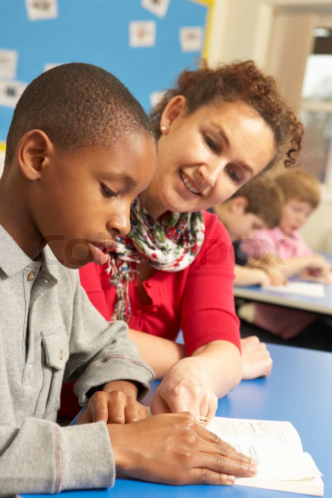 Skoledreng studere i klasseværelset med læreren | Stock foto | Colourbox