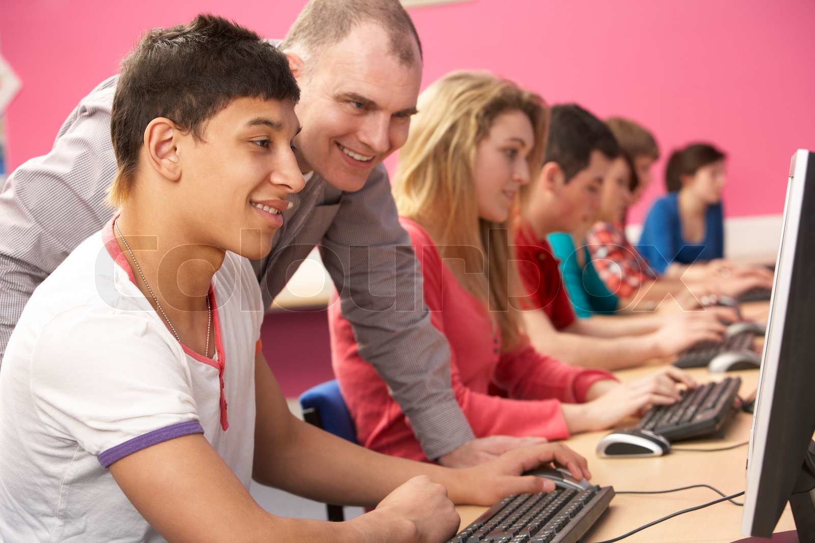 Teenage Students In IT Class Using Computers In Classroom With Tutor ...