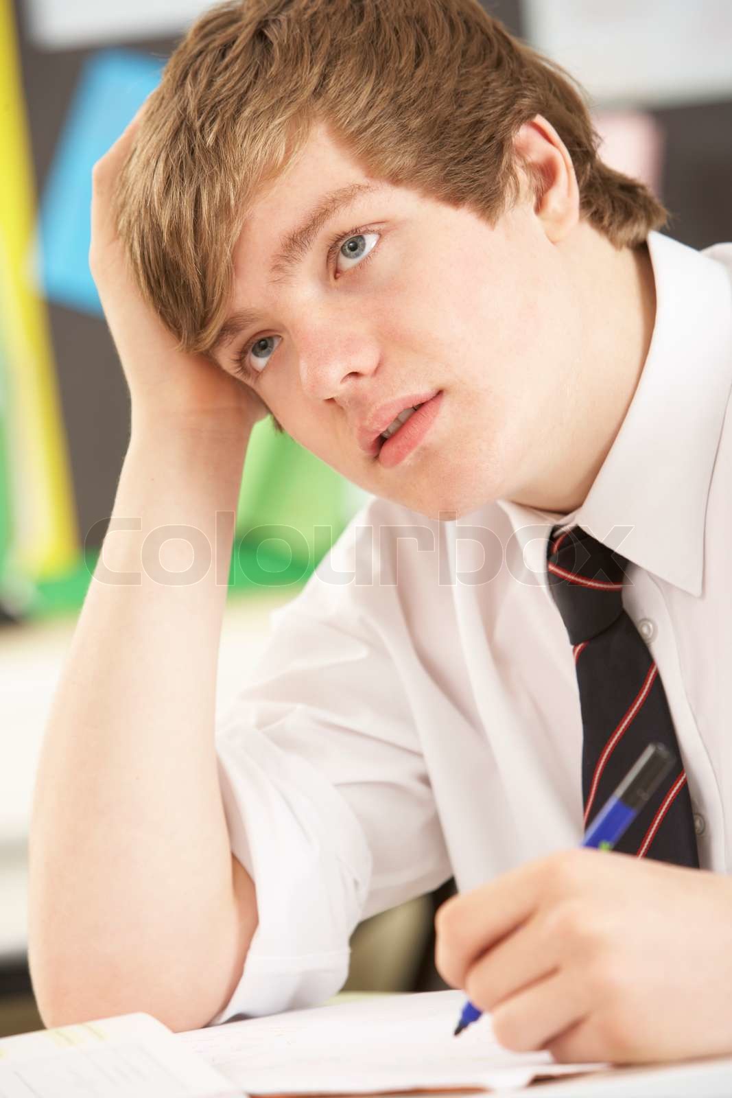 Stressed Male Teenage Student Studying In Classroom | Stock image ...