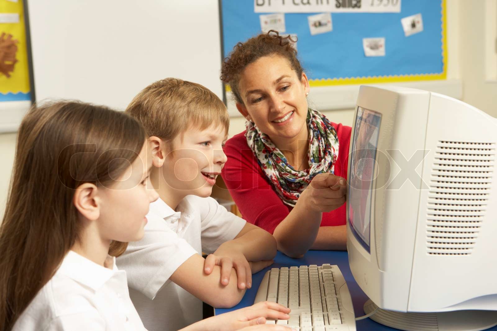 Schulkinder in IT Class Using Computer mit Lehrer | Stock Bild | Colourbox