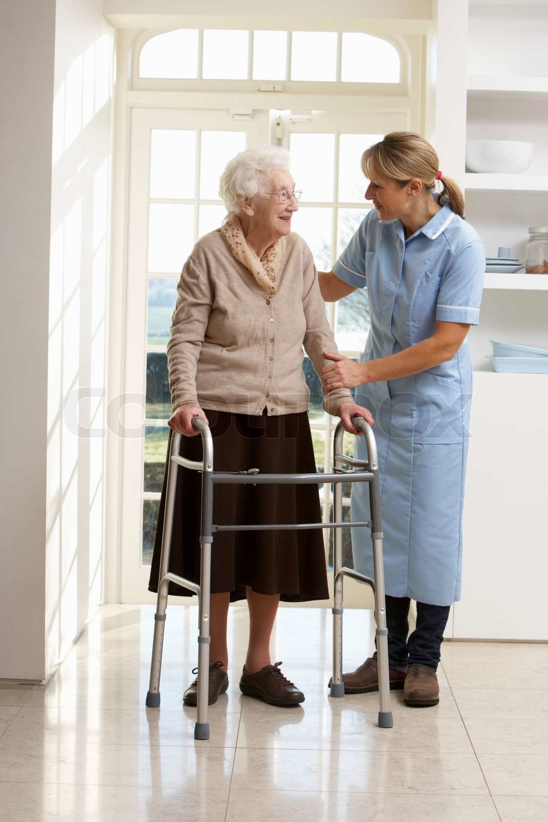 Carer Helping Elderly Senior Woman Using Walking Frame | Stock image ...
