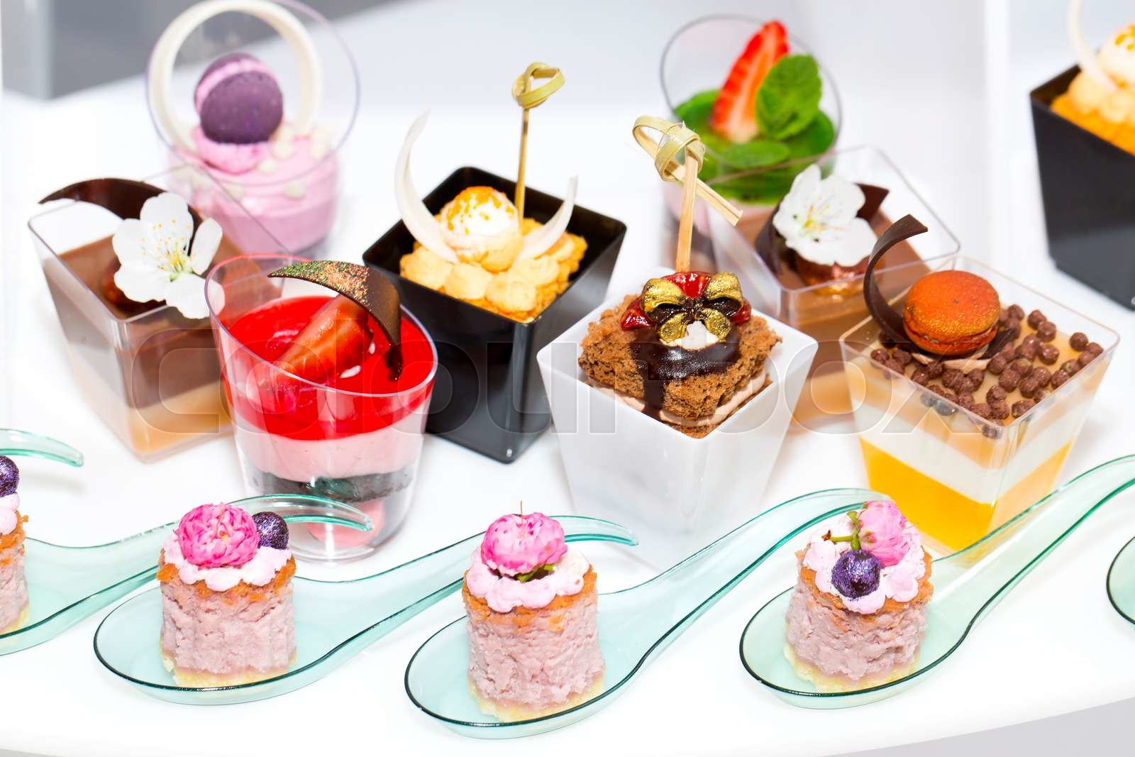 mini canapes in plastic cups decorated with edible flowers | Stock ...