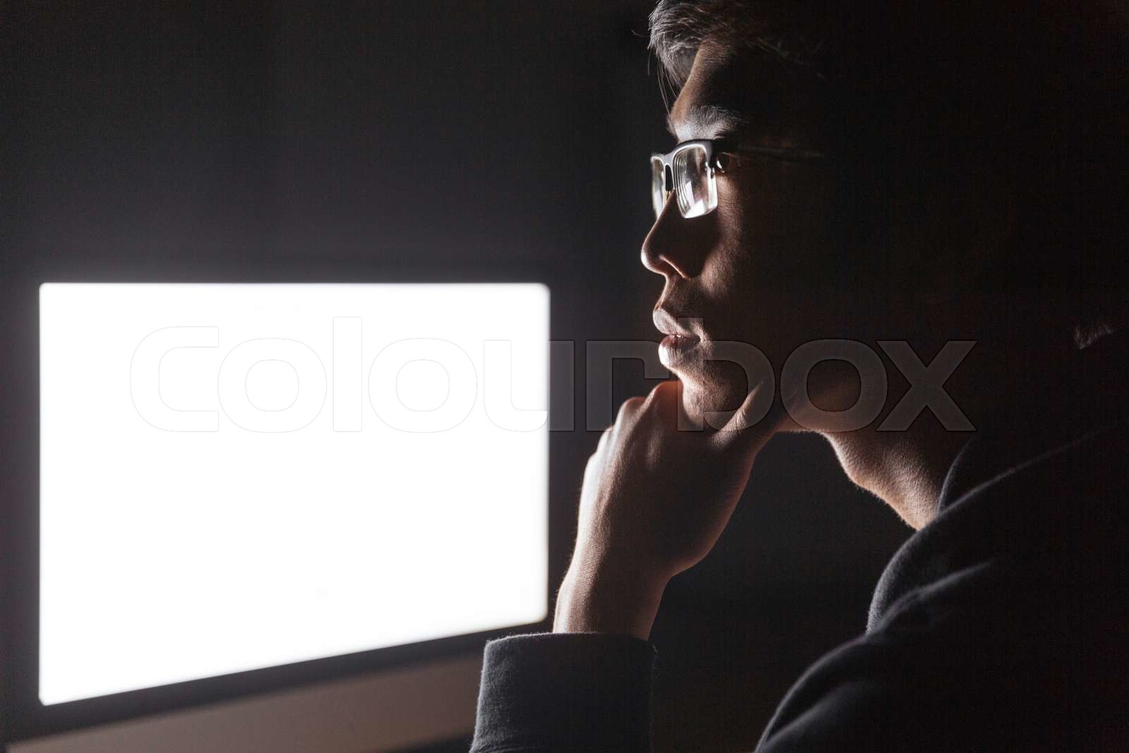 Pensive young man thinking and using blank screen computer | Stock ...