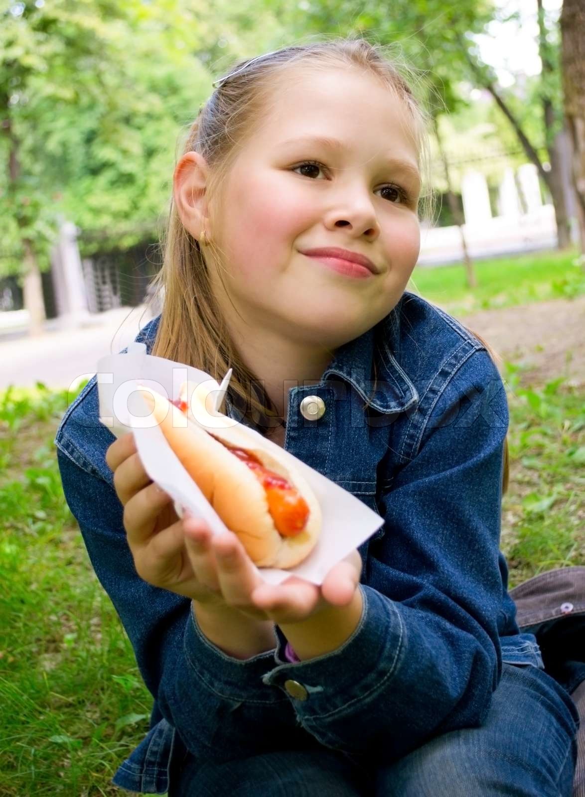 Den smukke pige spiser hotdog | Stock foto | Colourbox