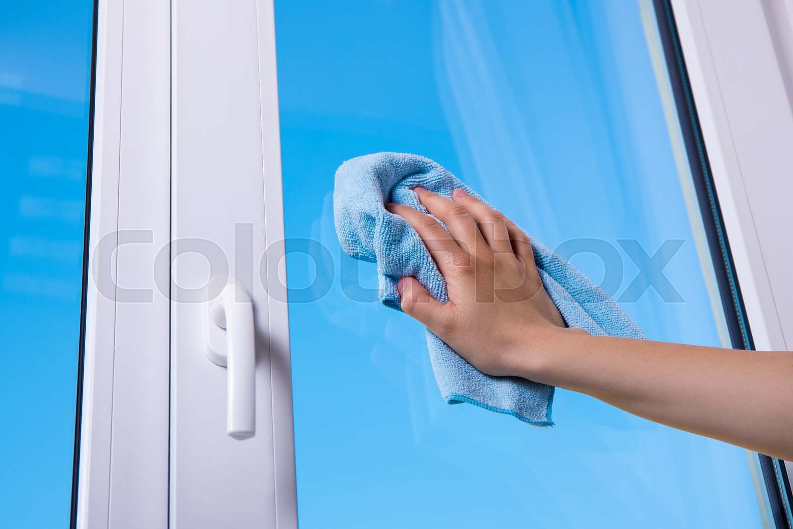 woman's hand cleaning window with special rag | Stock image | Colourbox
