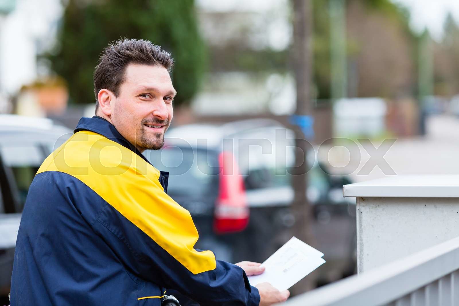 Postman delivering letters to mailbox of recipient | Stock image ...