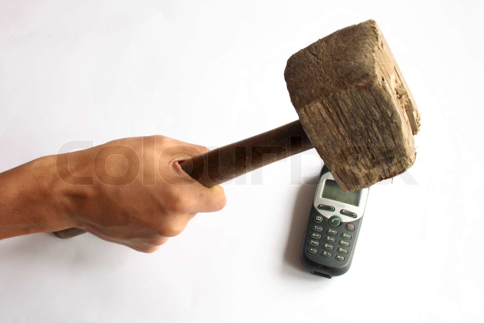 On a photo a hammer above mobile phone | Stock image | Colourbox