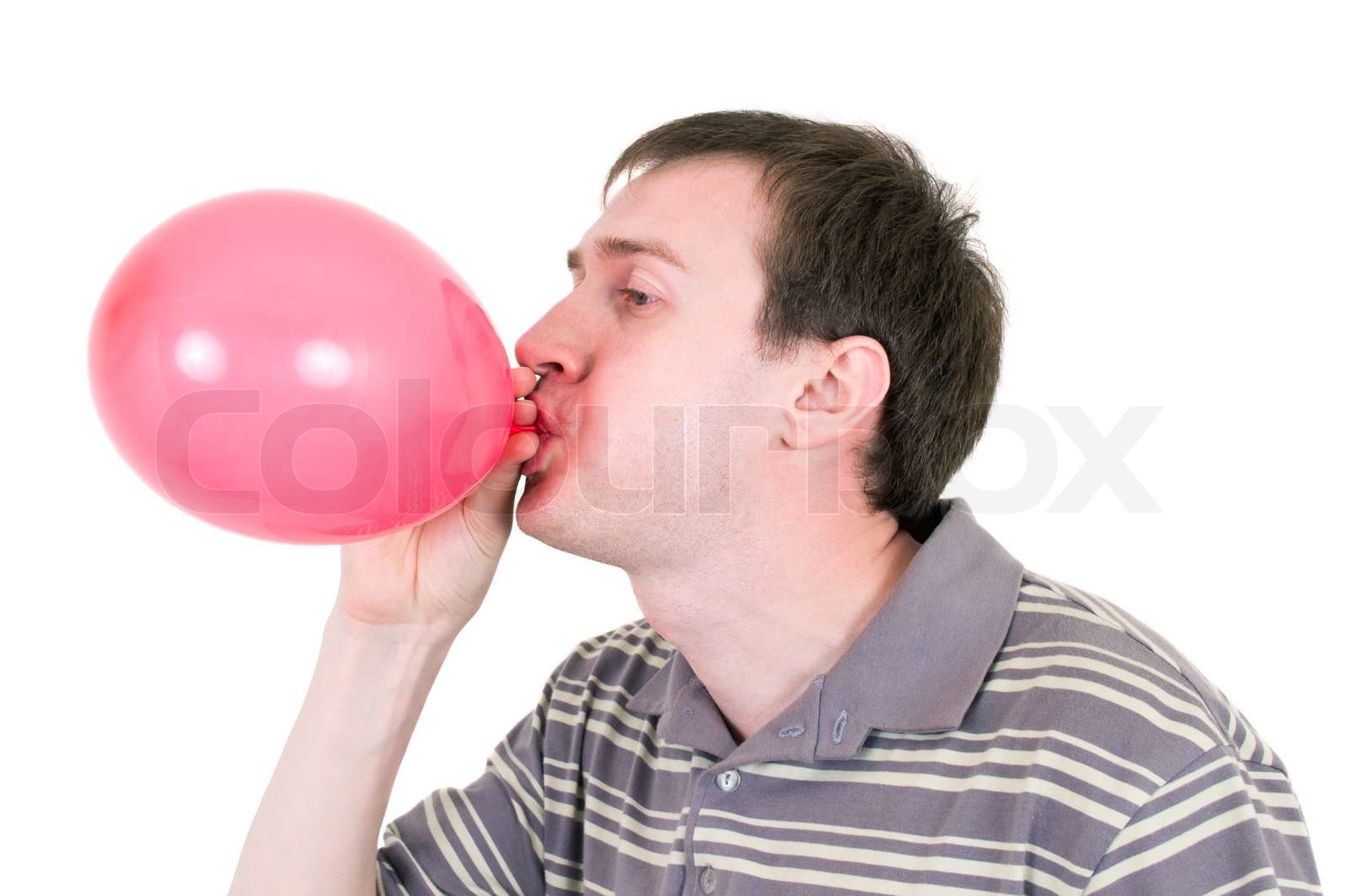 man inflating red balloon | Stock image | Colourbox