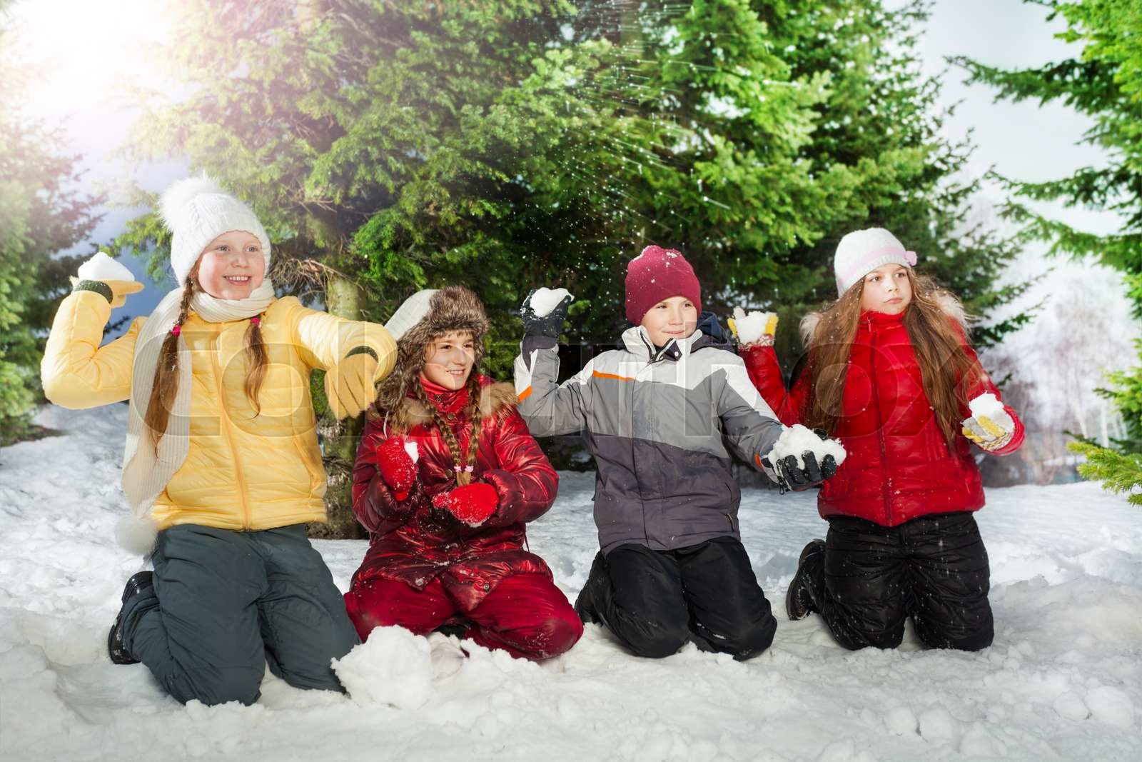 Happy kids throwing snowballs in snowy forest | Stock image | Colourbox