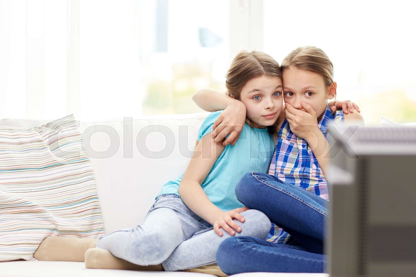 scared little girls watching horror on tv at home | Stock image | Colourbox