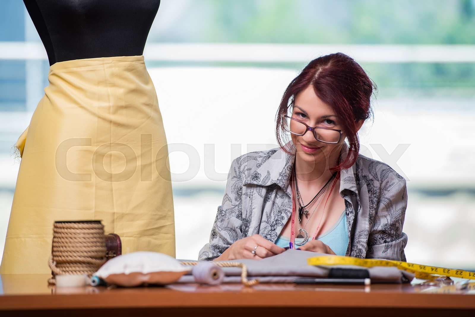 Woman tailor working at her desk | Stock image | Colourbox