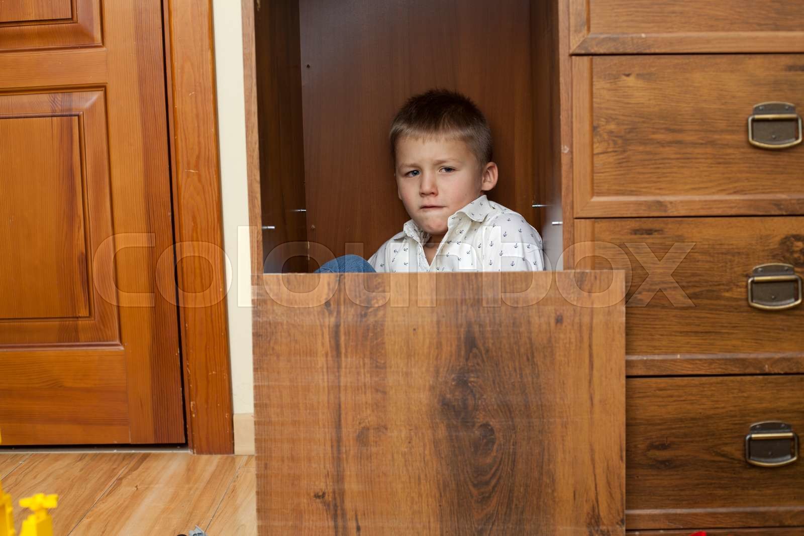 little boy hiding in a cupboard | Stock image | Colourbox