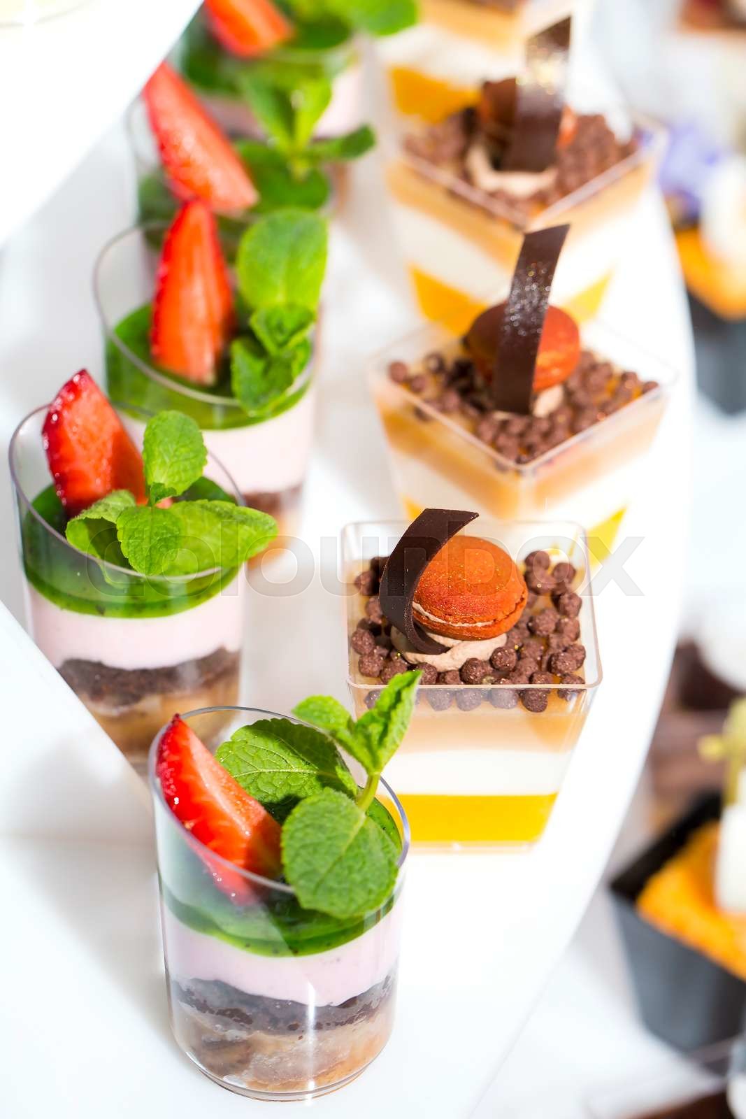 mini canapes in plastic cups decorated with edible flowers | Stock ...