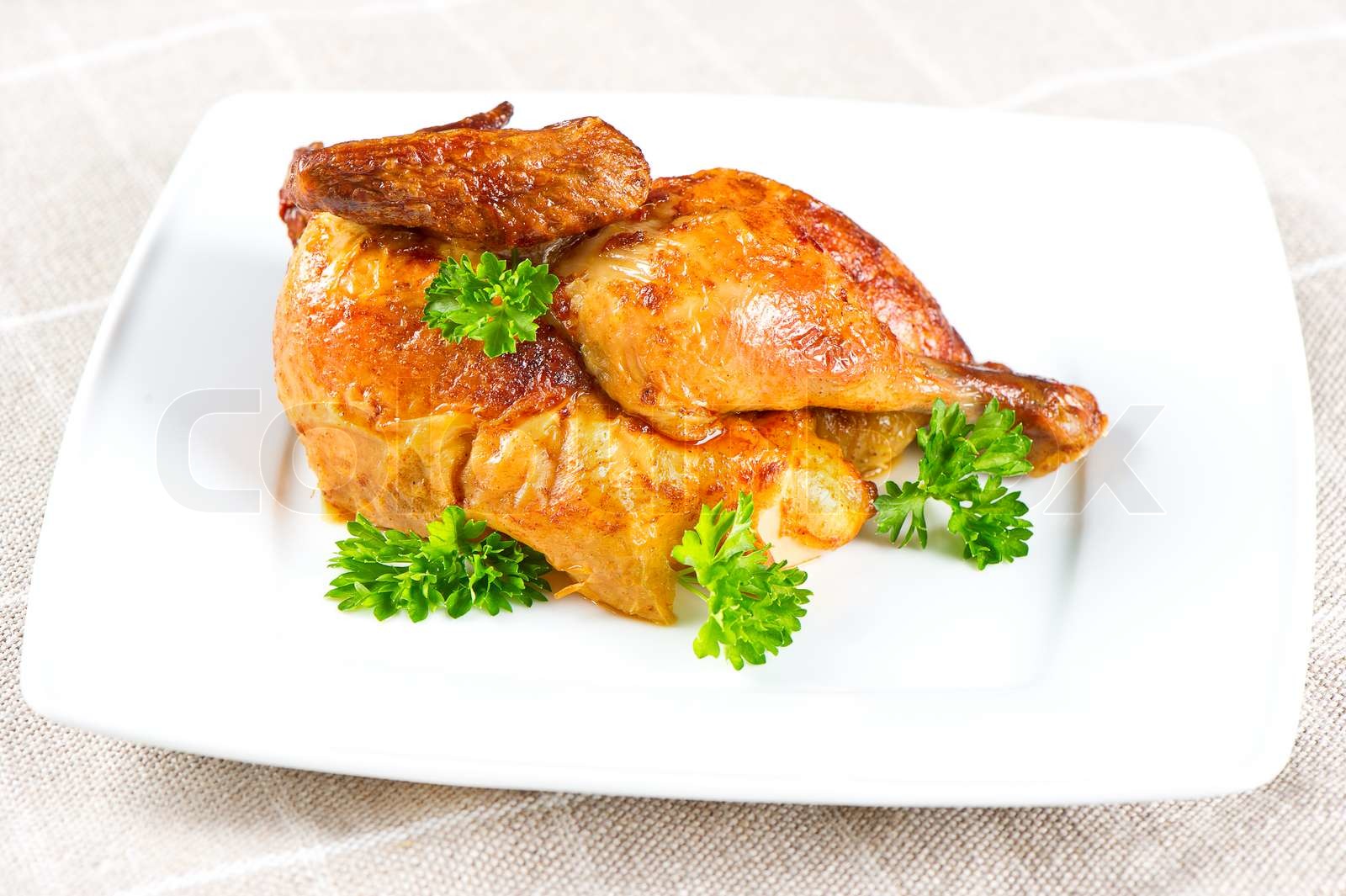 gegrilltes Hähnchen mit grüner Petersilie auf weißen Teller dekoriert ...