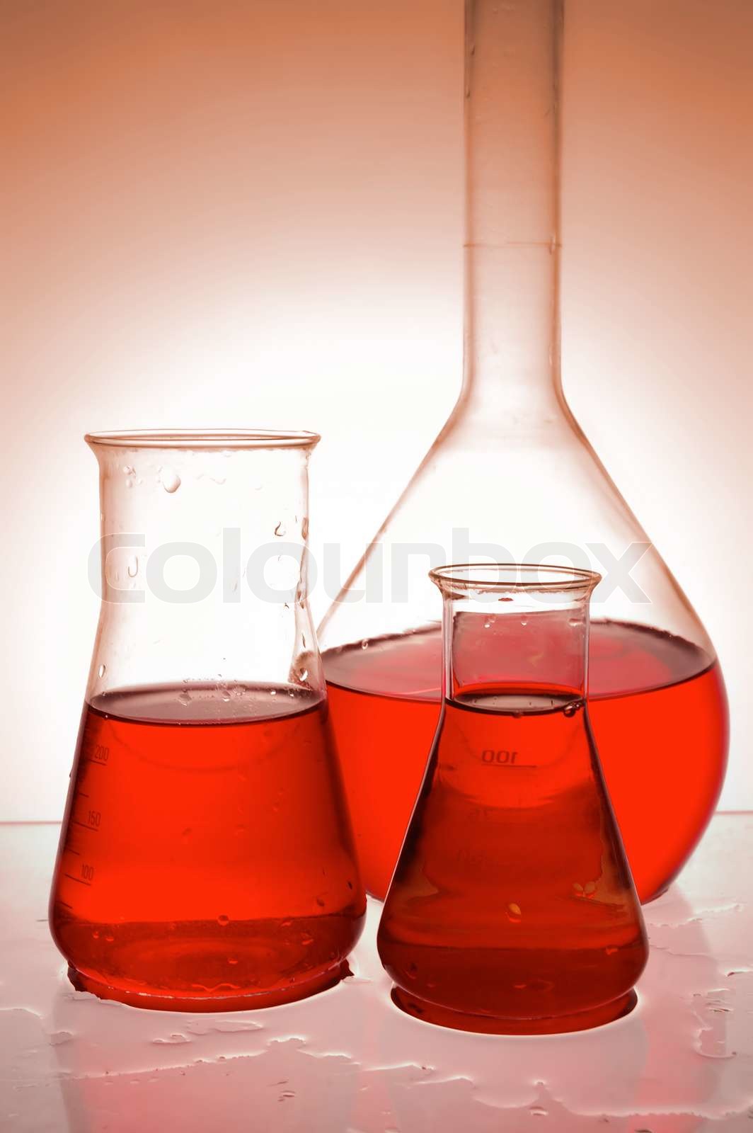 Chemical retorts on glass table | Stock image | Colourbox