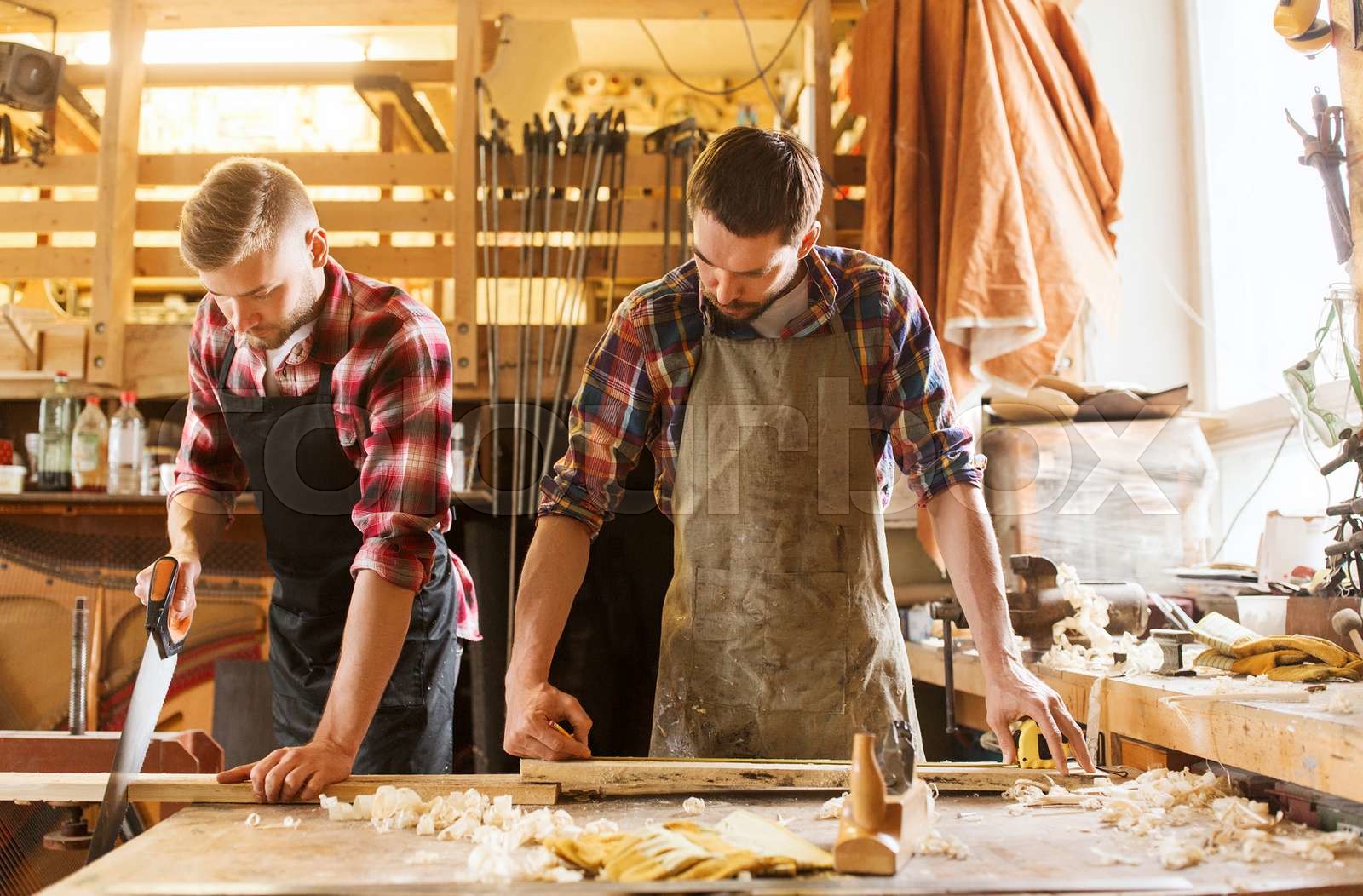 carpenters working with saw and wood at workshop | Stock image | Colourbox