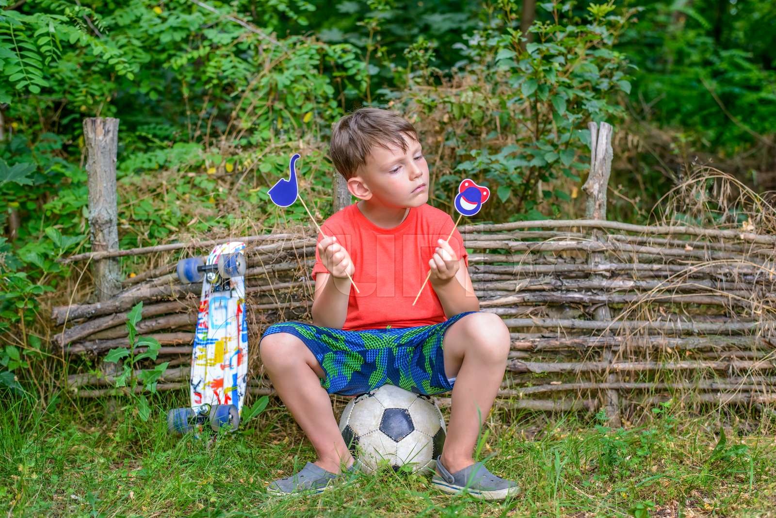 Befuddled boy with symbols on sticks outside | Stock image | Colourbox