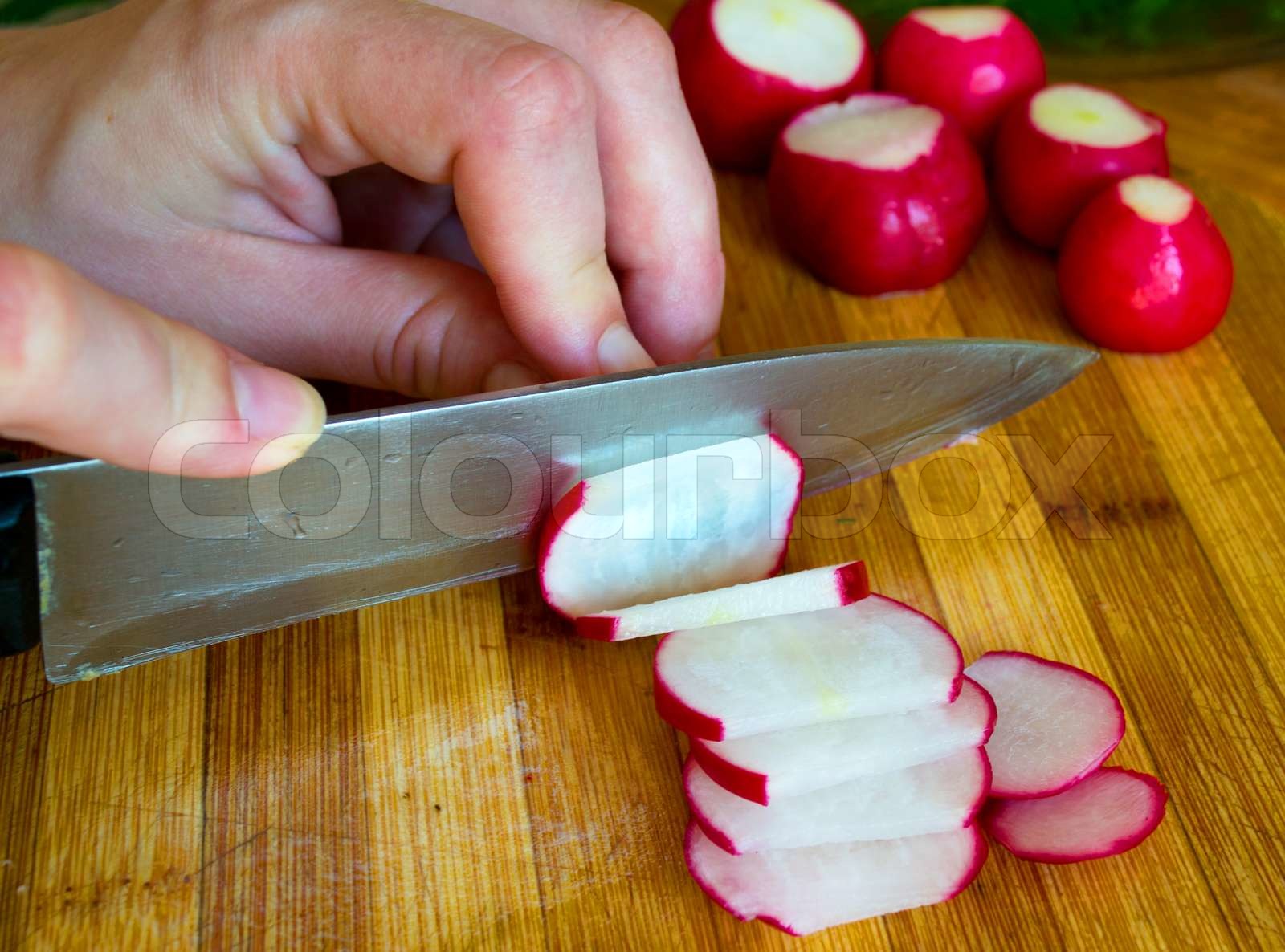 Cutting of garden radish for salad | Stock image | Colourbox