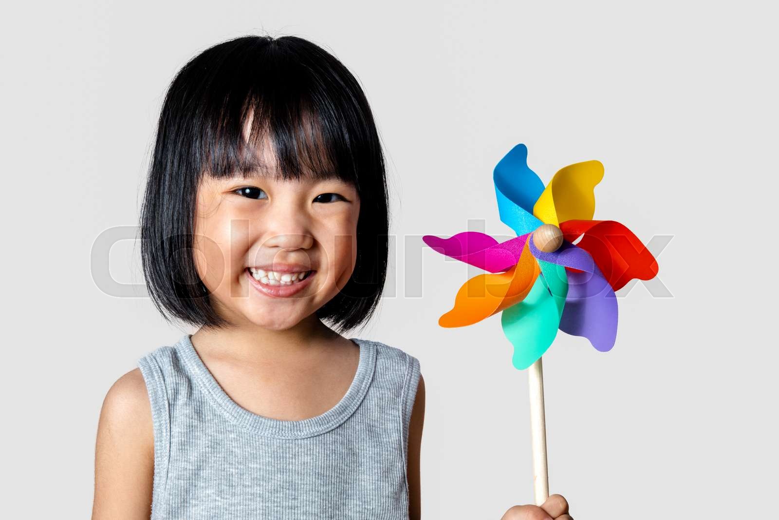 Asian Little Chinese Girl Playing Colorful Pinwheel | Stock image | Colourbox