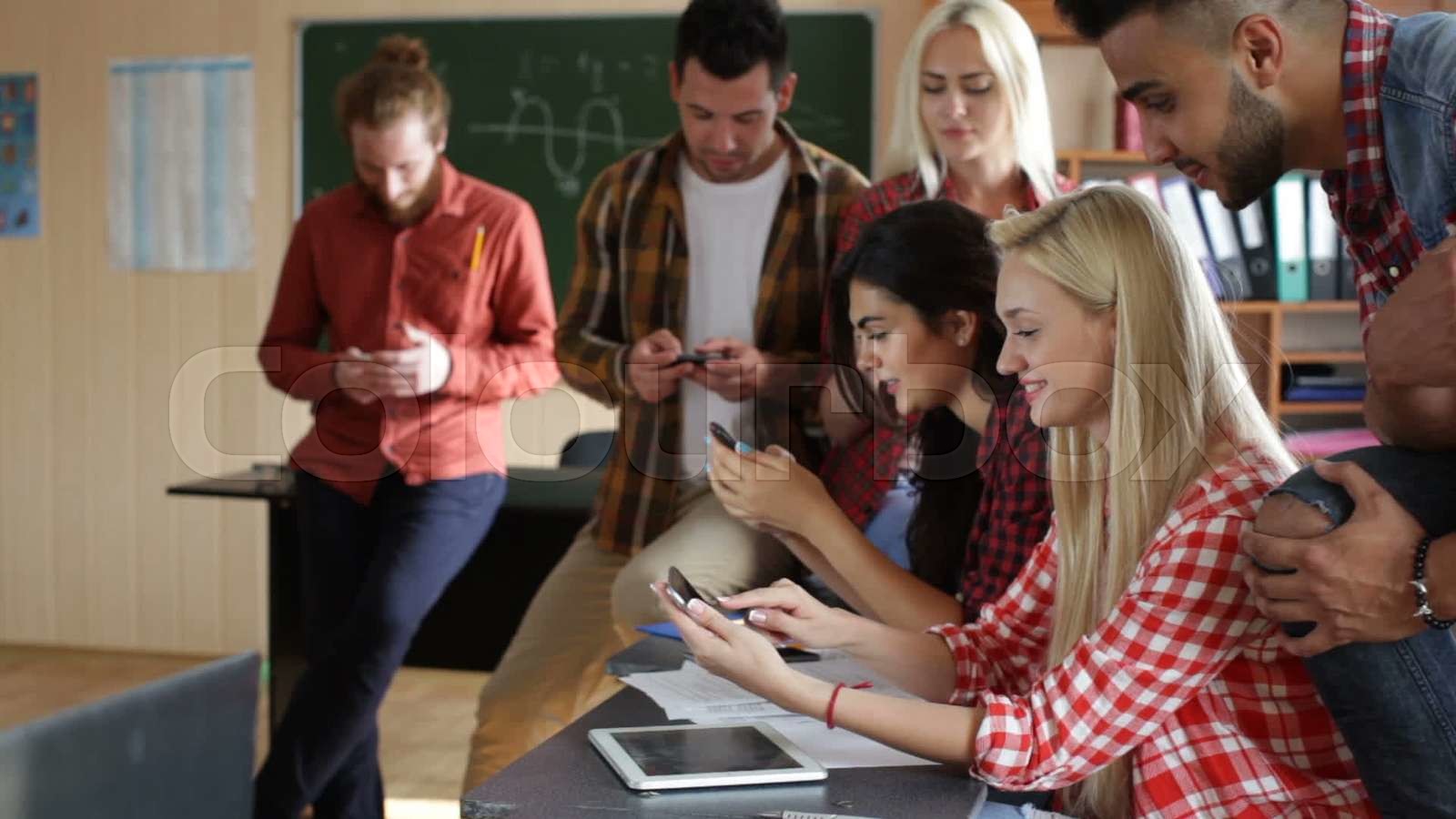 Students using smart phone sitting desk university classroom | Stock ...