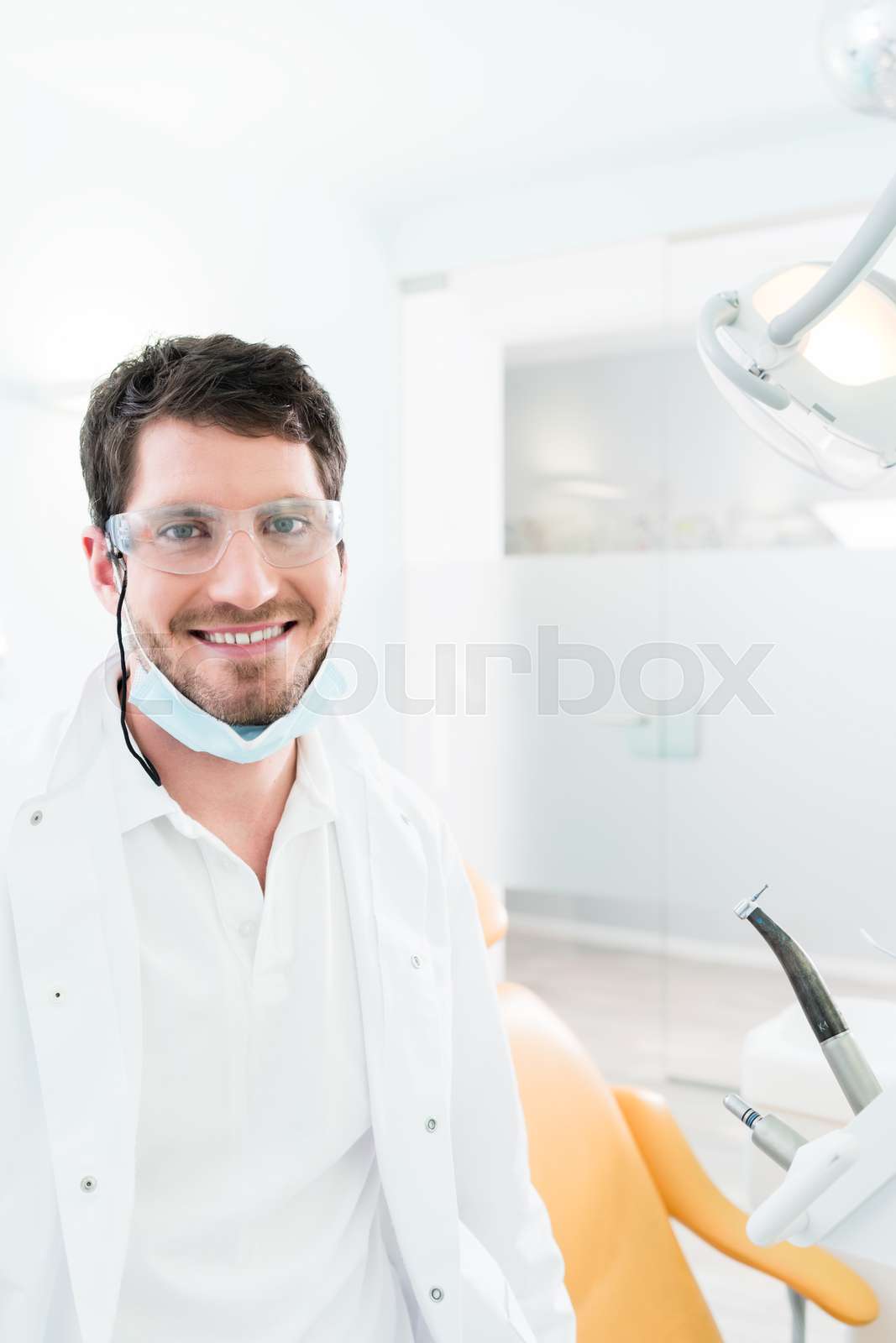 Dentist standing in dental surgery | Stock image | Colourbox