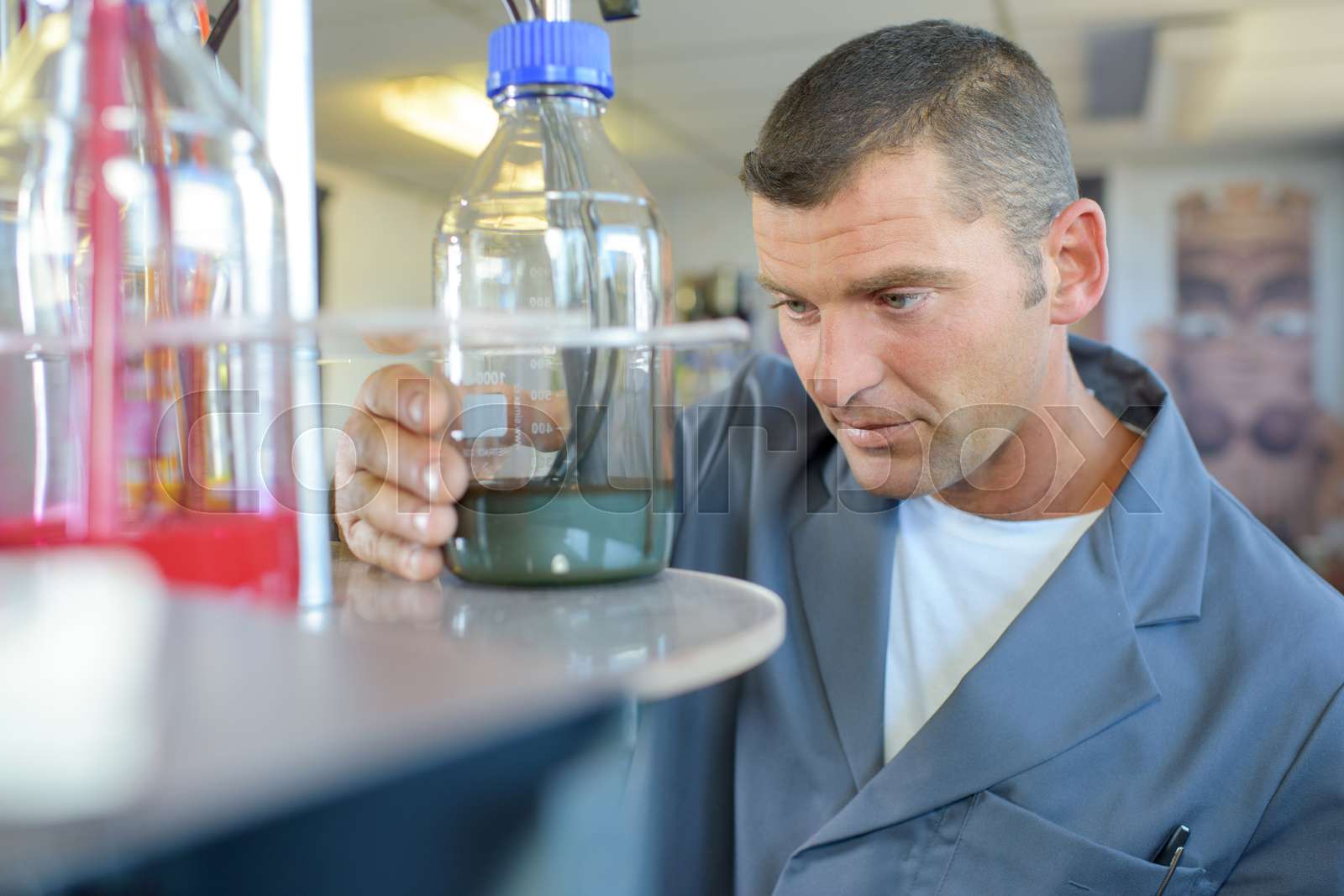 Man looking at glass jar | Stock image | Colourbox