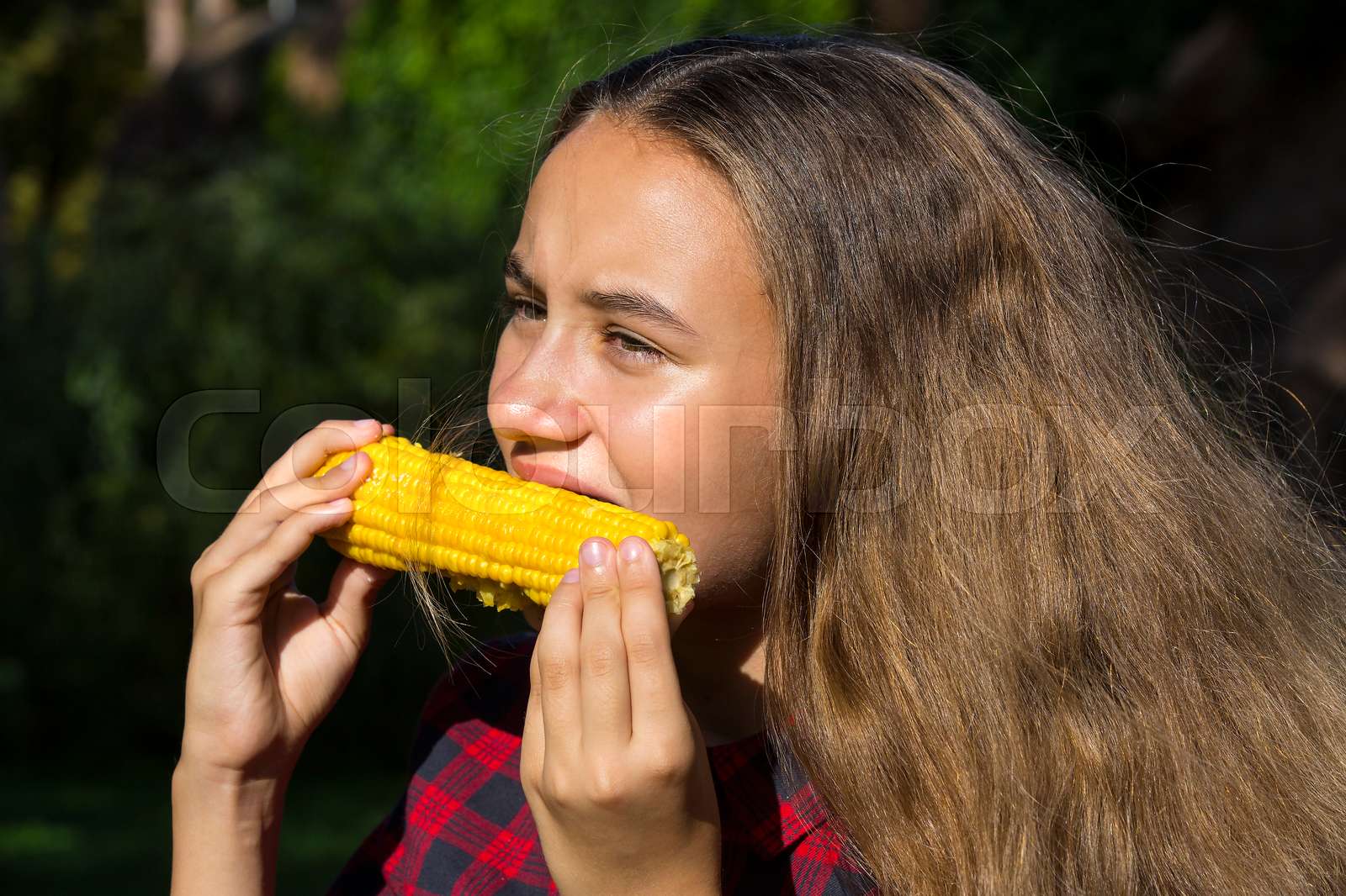 girl eating sweet corn on the nature of the day | Stock image | Colourbox