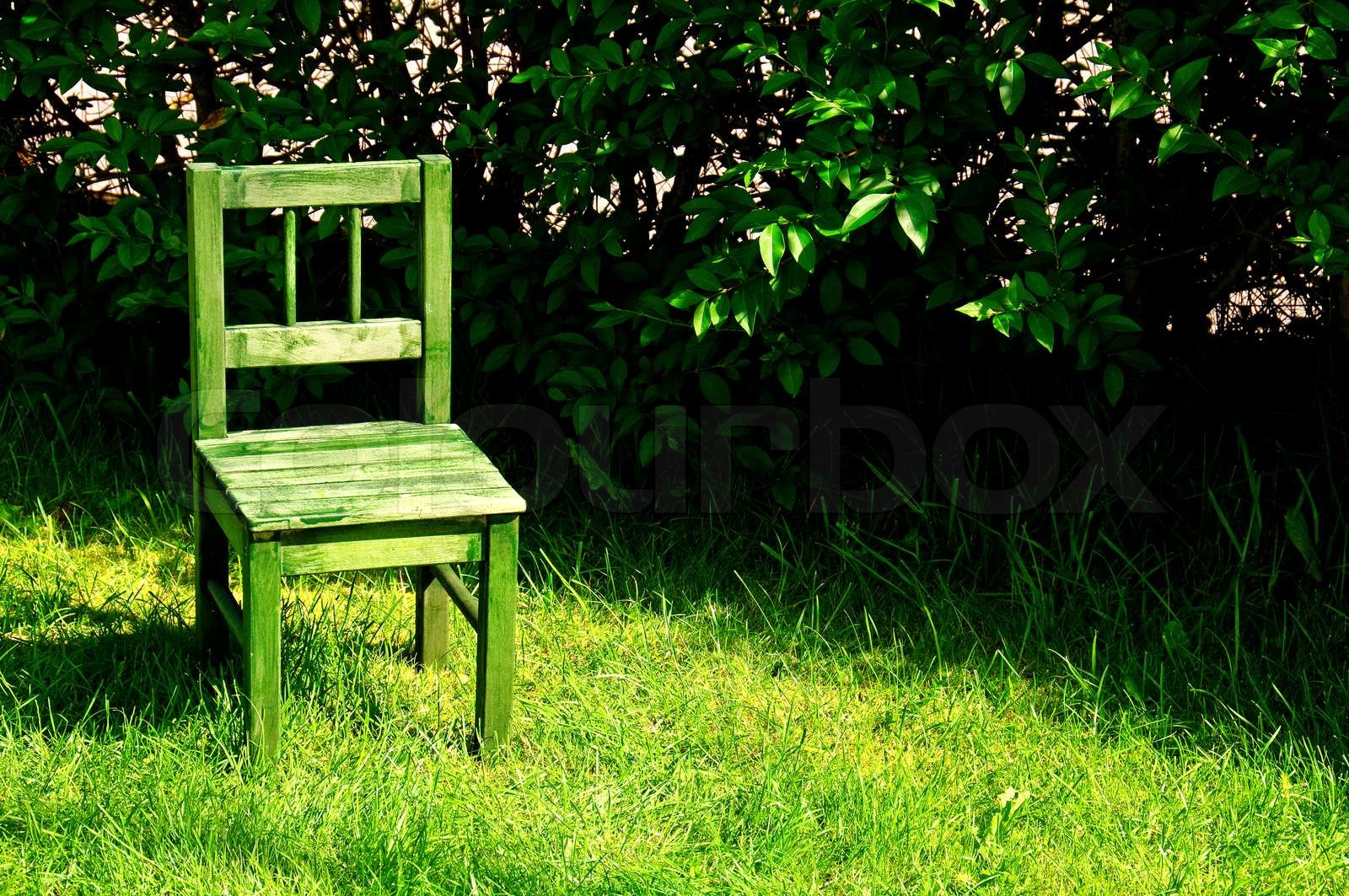 A small green chair in a garden | Stock image | Colourbox