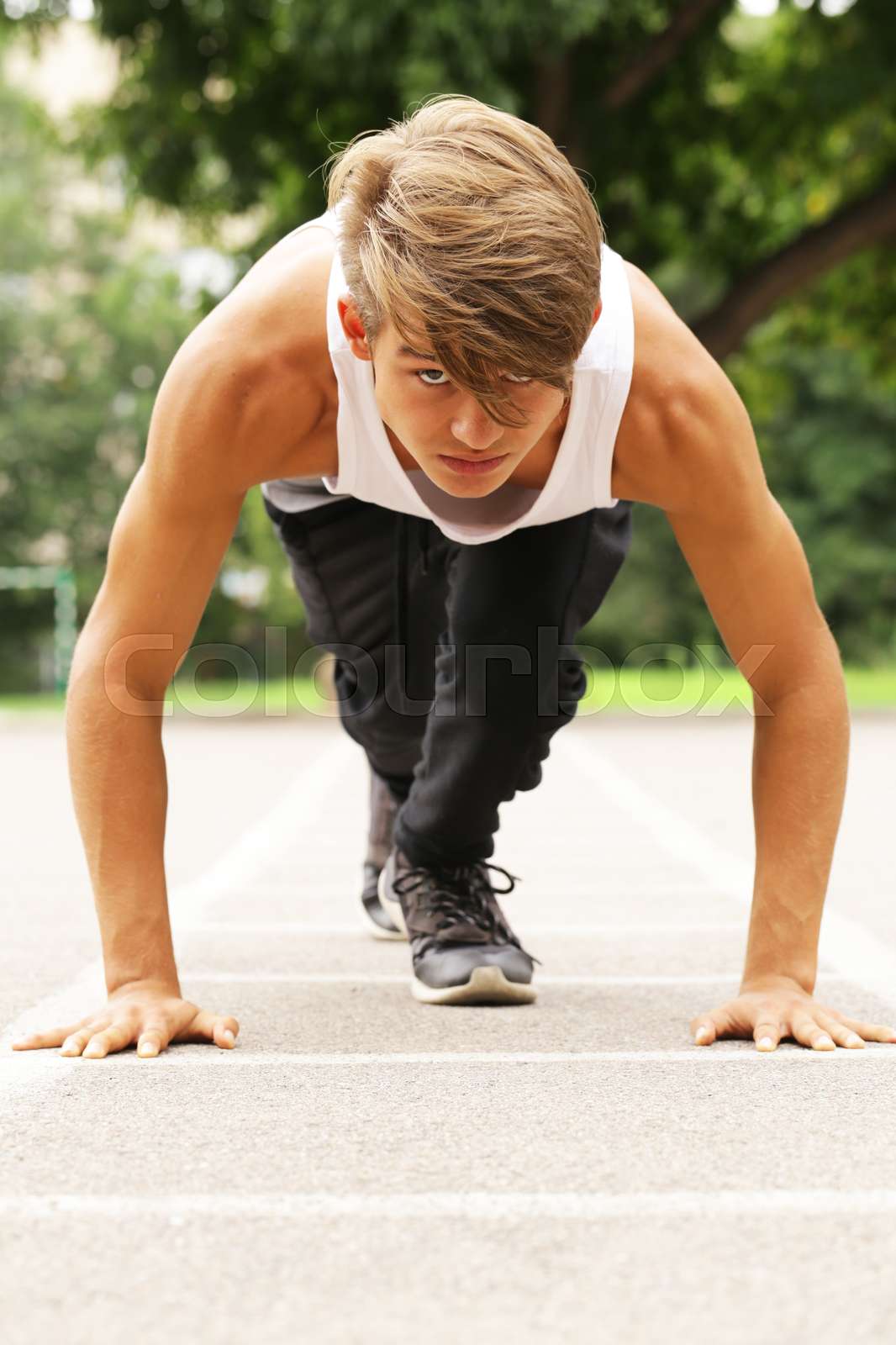 Young sports guy at the start, ready to run | Stock image | Colourbox