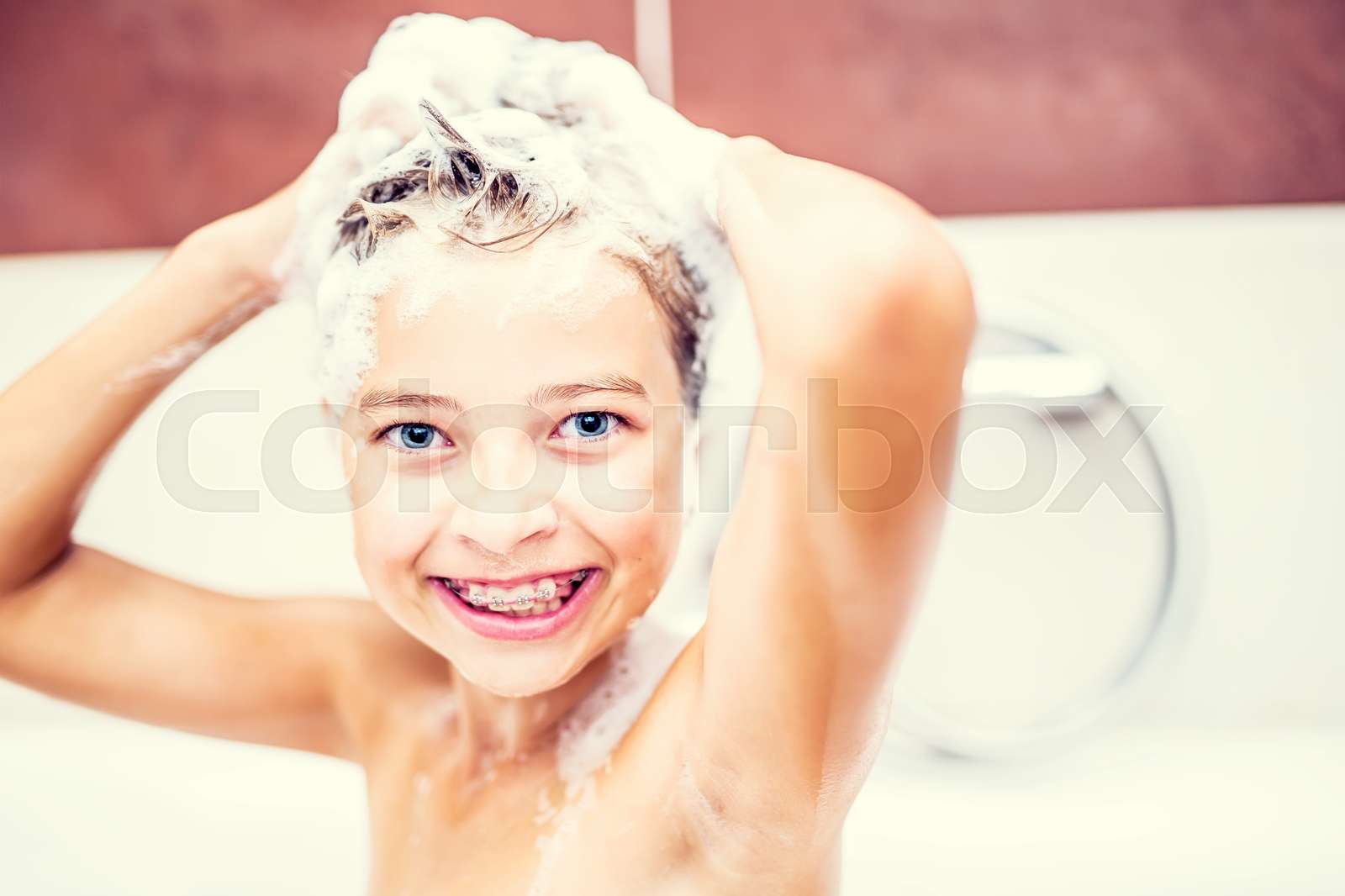 Cute young girl in shower washing hair and face with shampoo | Stock ...