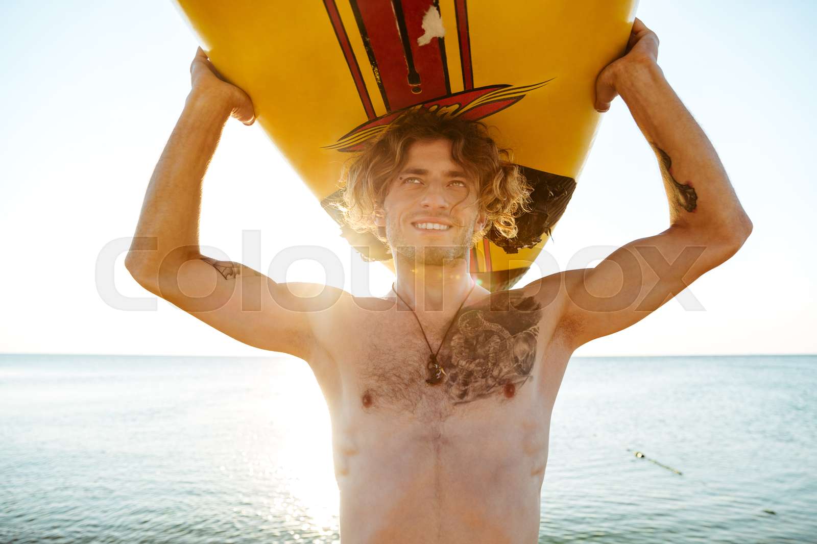 Close up face of handsome guy with surfboard on head | Stock image ...