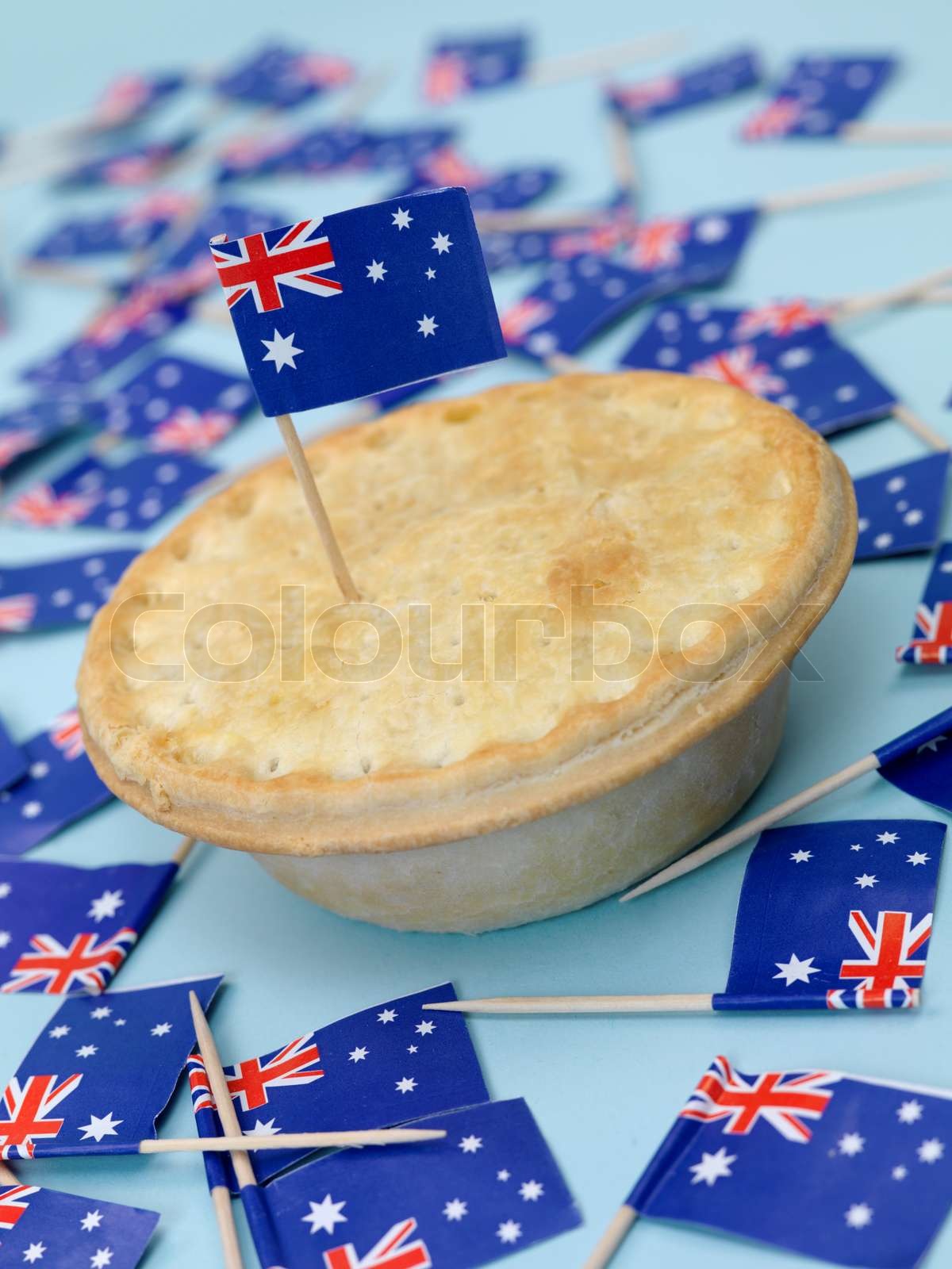 En australsk kød pie isoleret mod en blå baggrund med australske flag ...