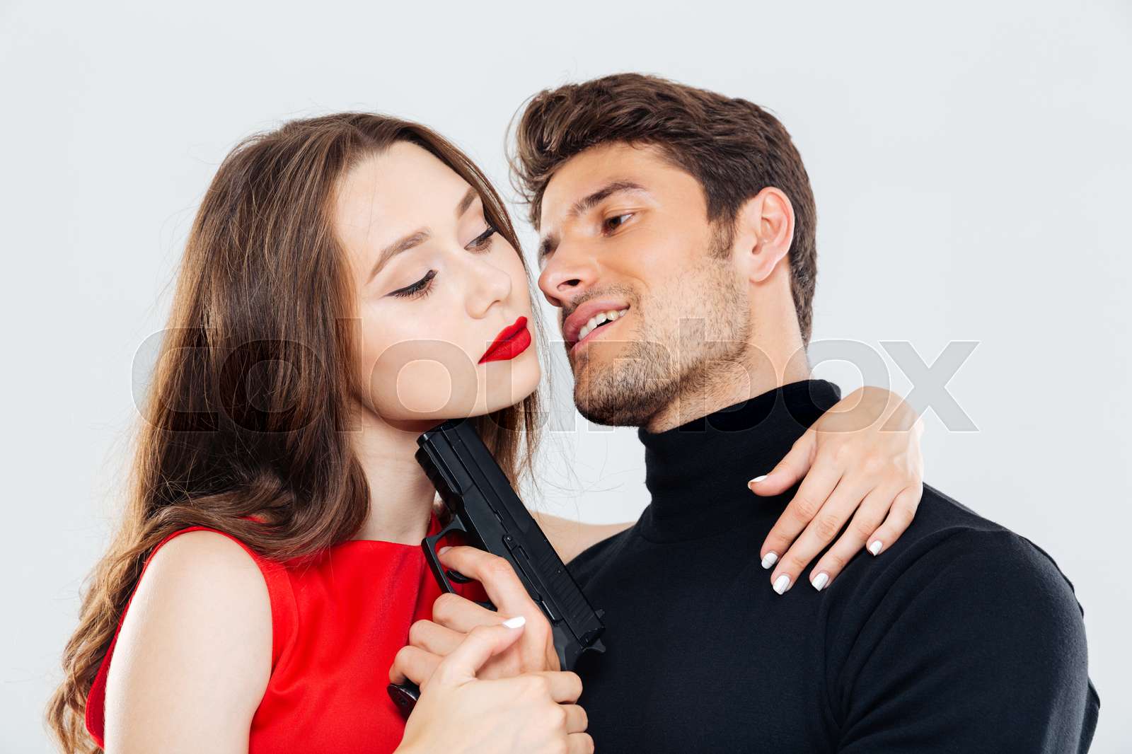 Sensual young couple hugging and posing with gun | Stock image | Colourbox