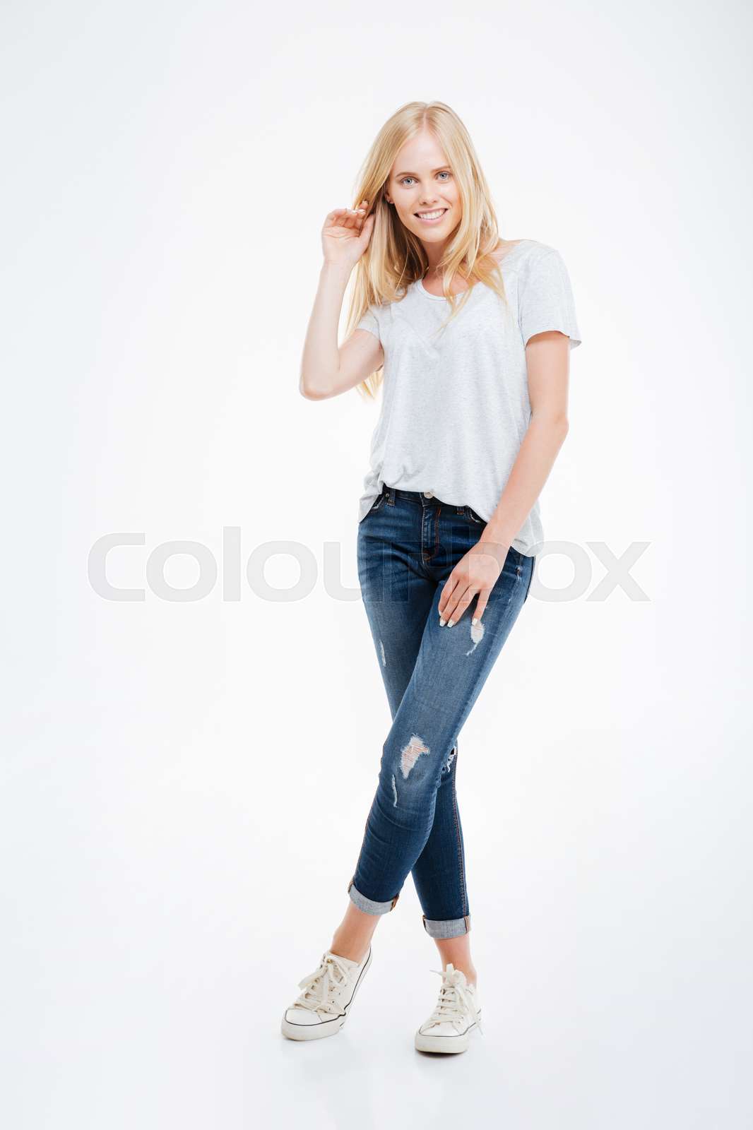 Full length portrait of a woman standing with legs crossed | Stock ...