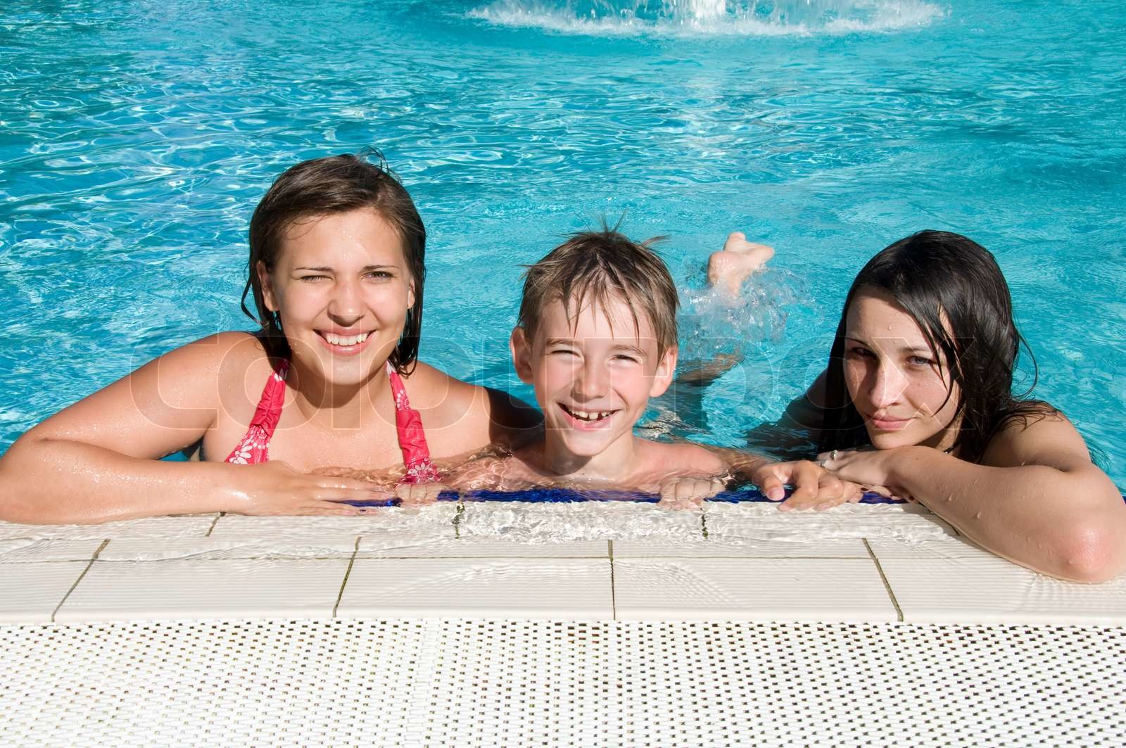 kids relaxing in a row on side of swimming pool | Stock image | Colourbox