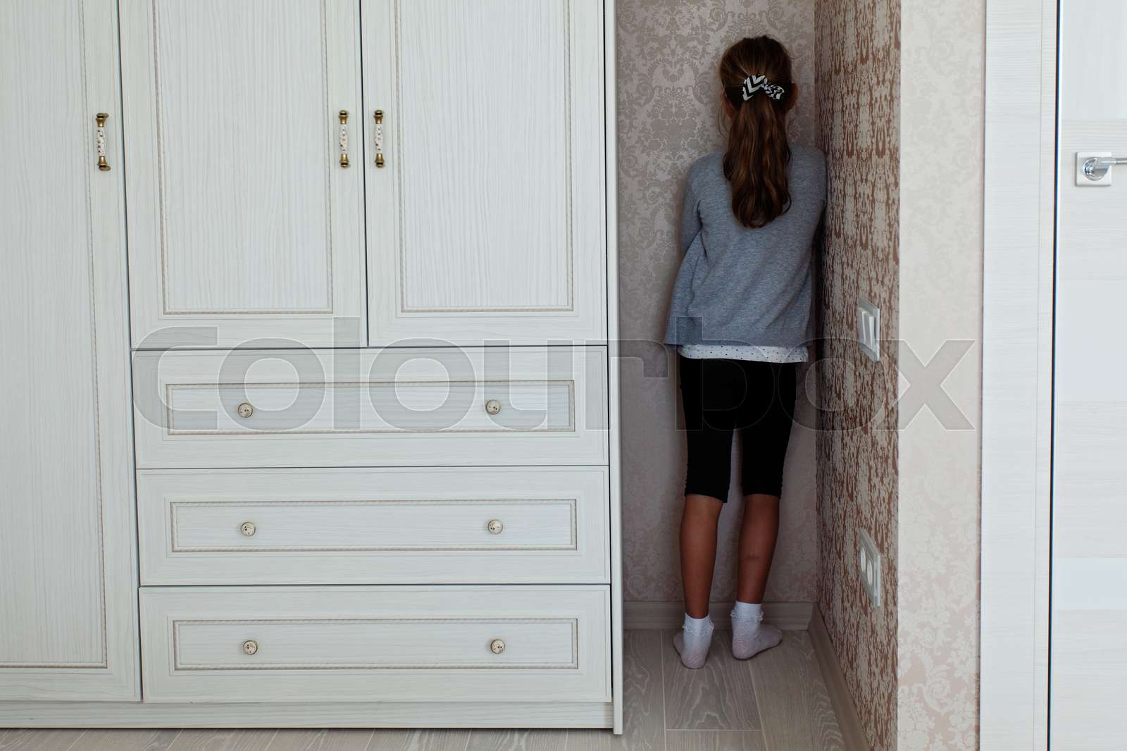 Little girl standing in the corner | Stock image | Colourbox
