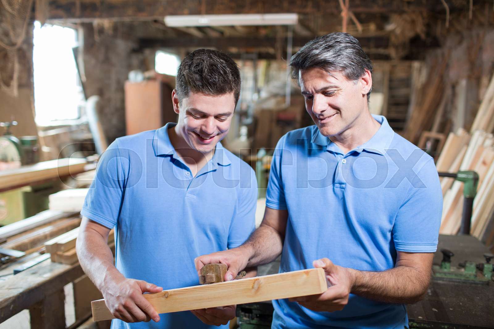 Carpenter Teaching Apprentice How To Measure Wood | Stock image | Colourbox
